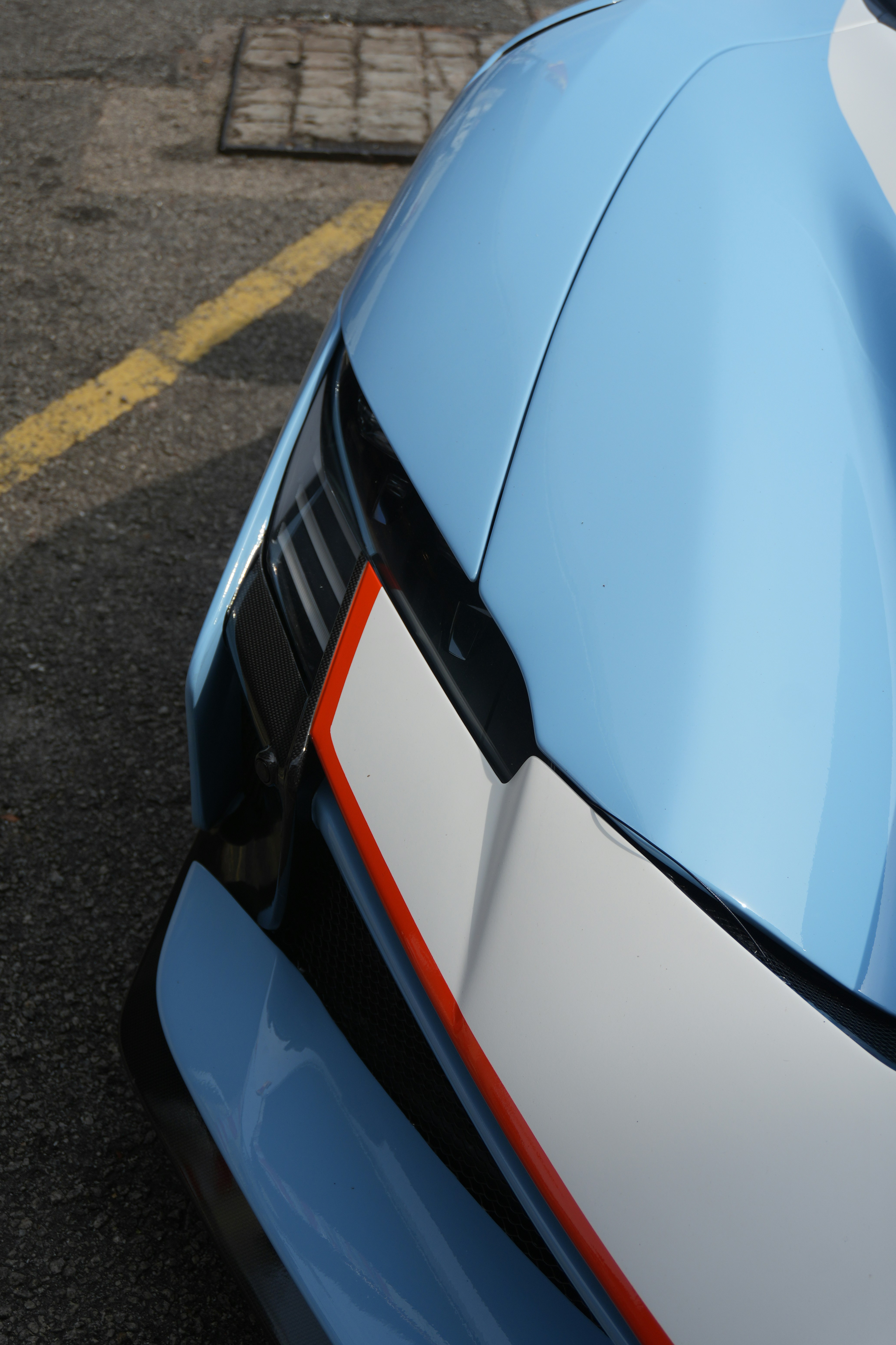 Front-Quarter of a Classic Blue Car: A Sleek Hood and Headlight Edge