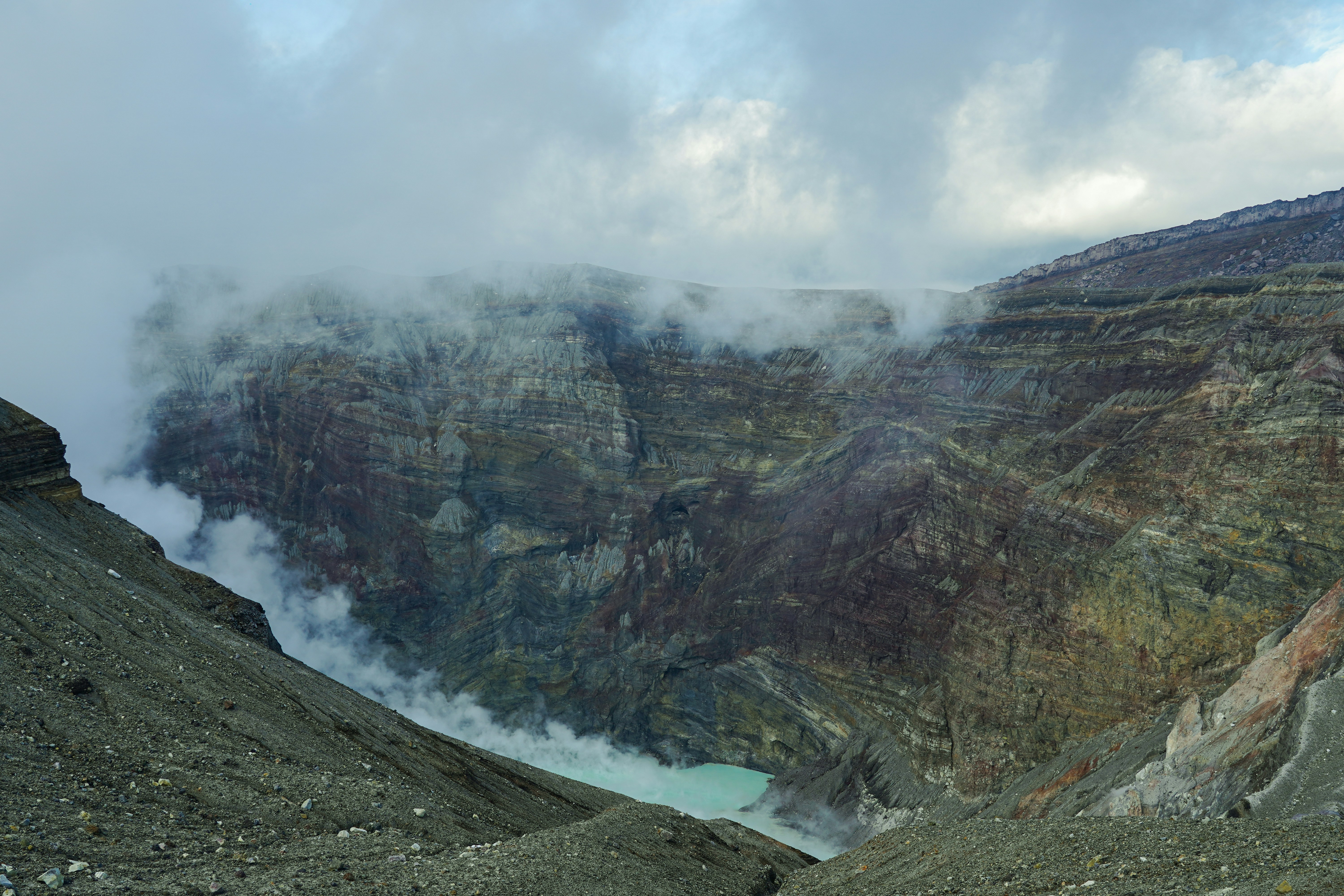 Misty crater edges: a volcanic caldera shrouded in clouds