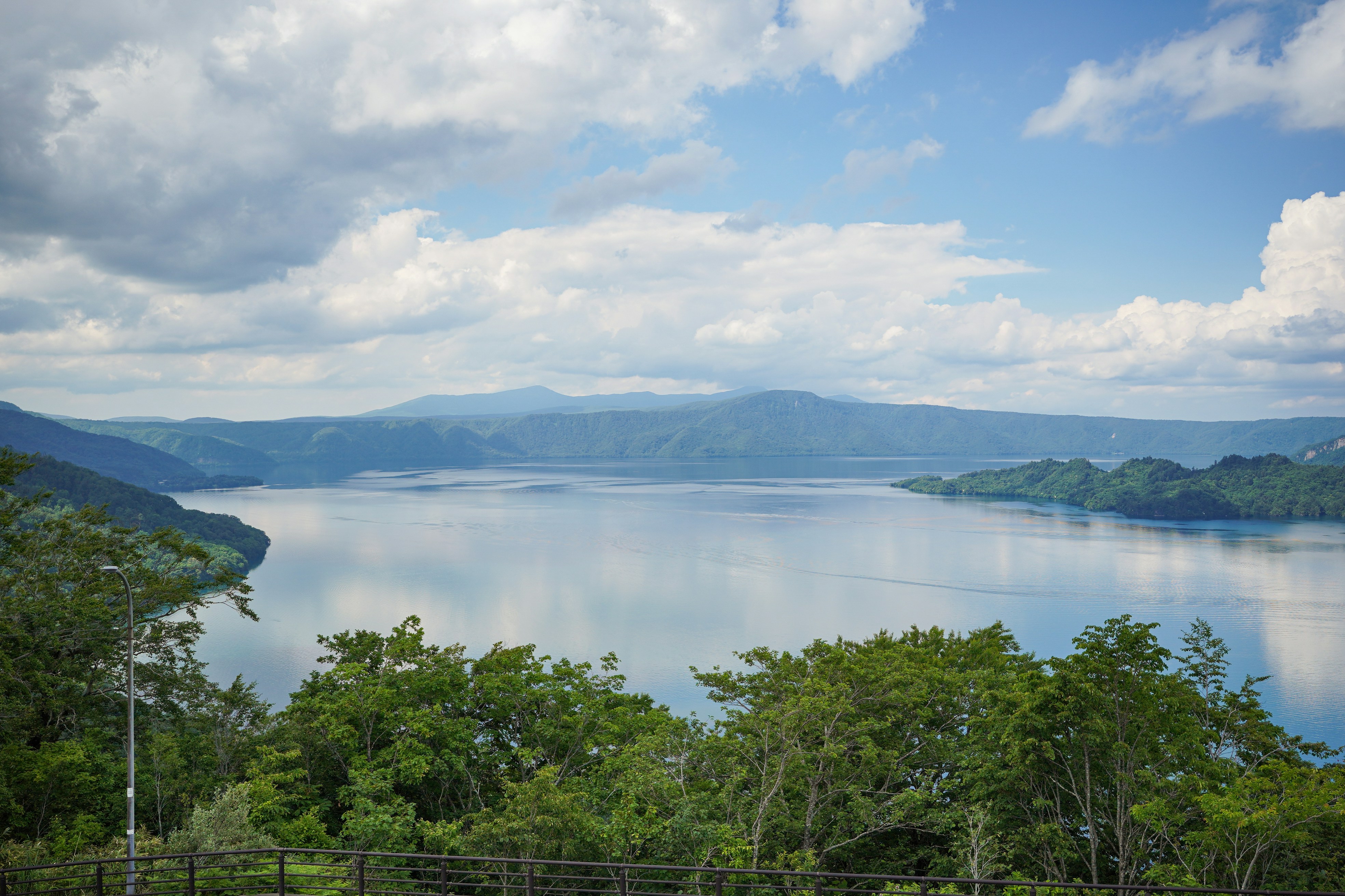 Lake Whisper: A Serene Vista Over Forested Hills