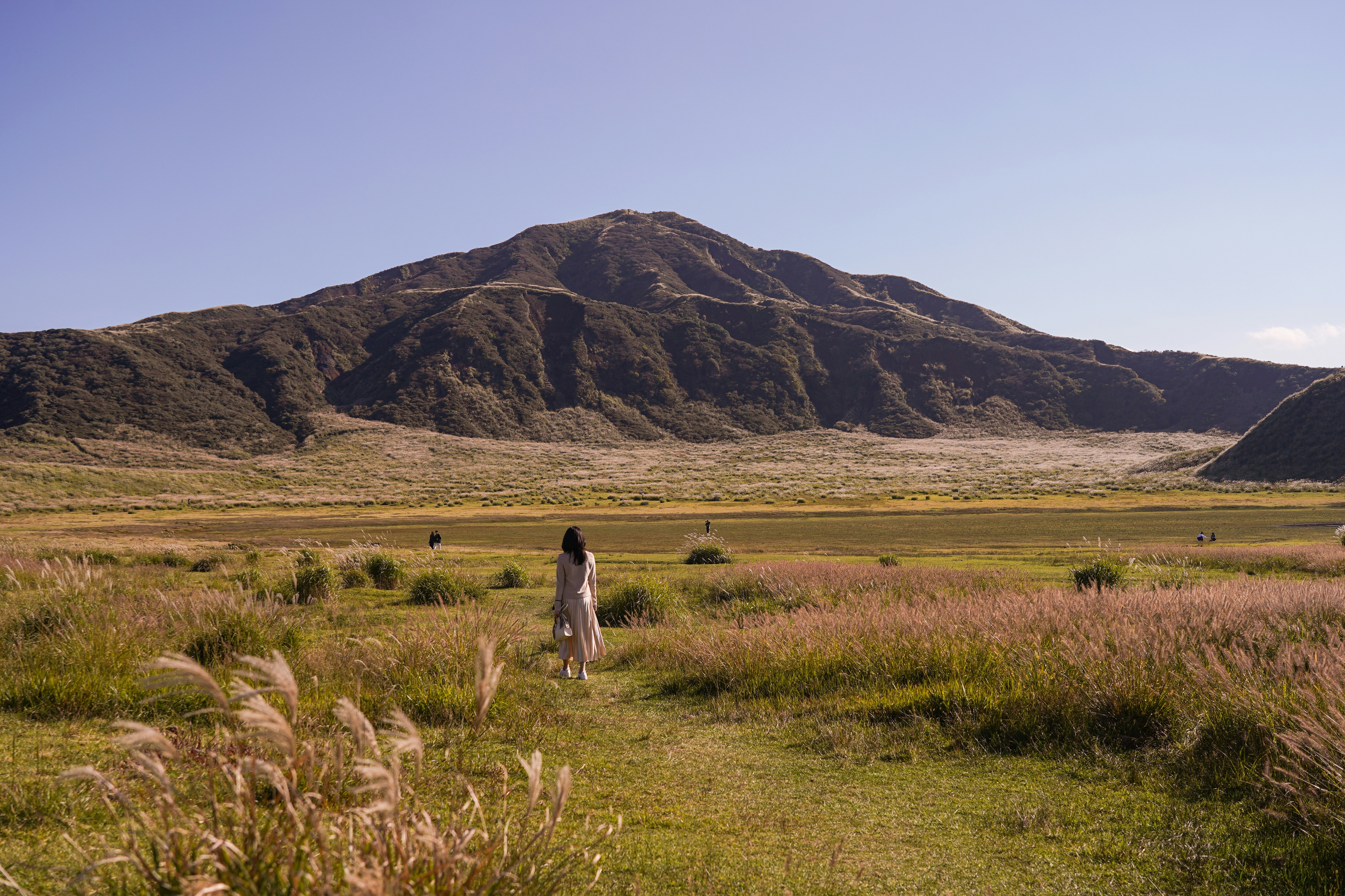  solitary wanderer in a sunlit valley under a rugged mountain