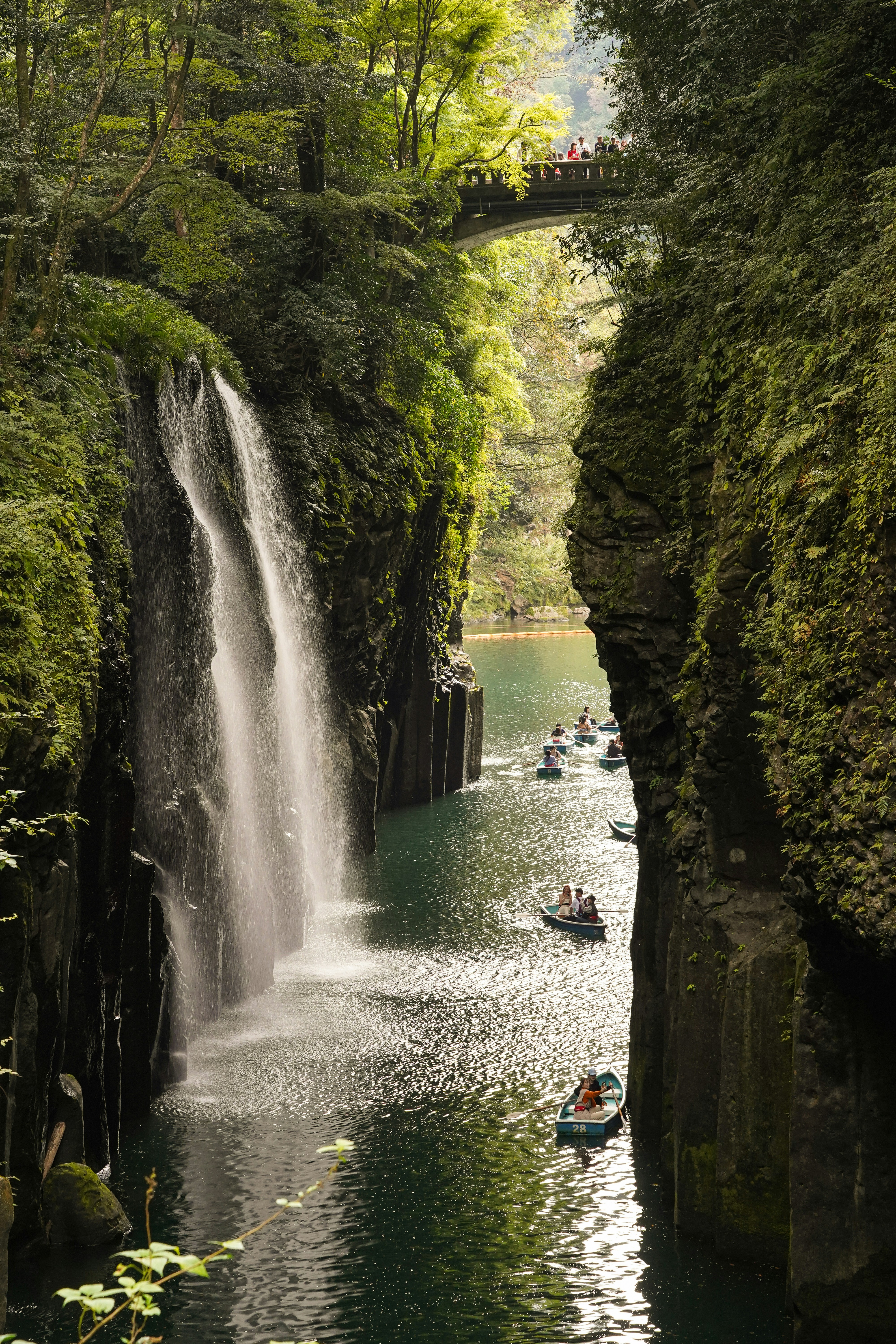 Gorge of the Falls: Boats Thread the Emerald Channel Under a Cliffside Bridge