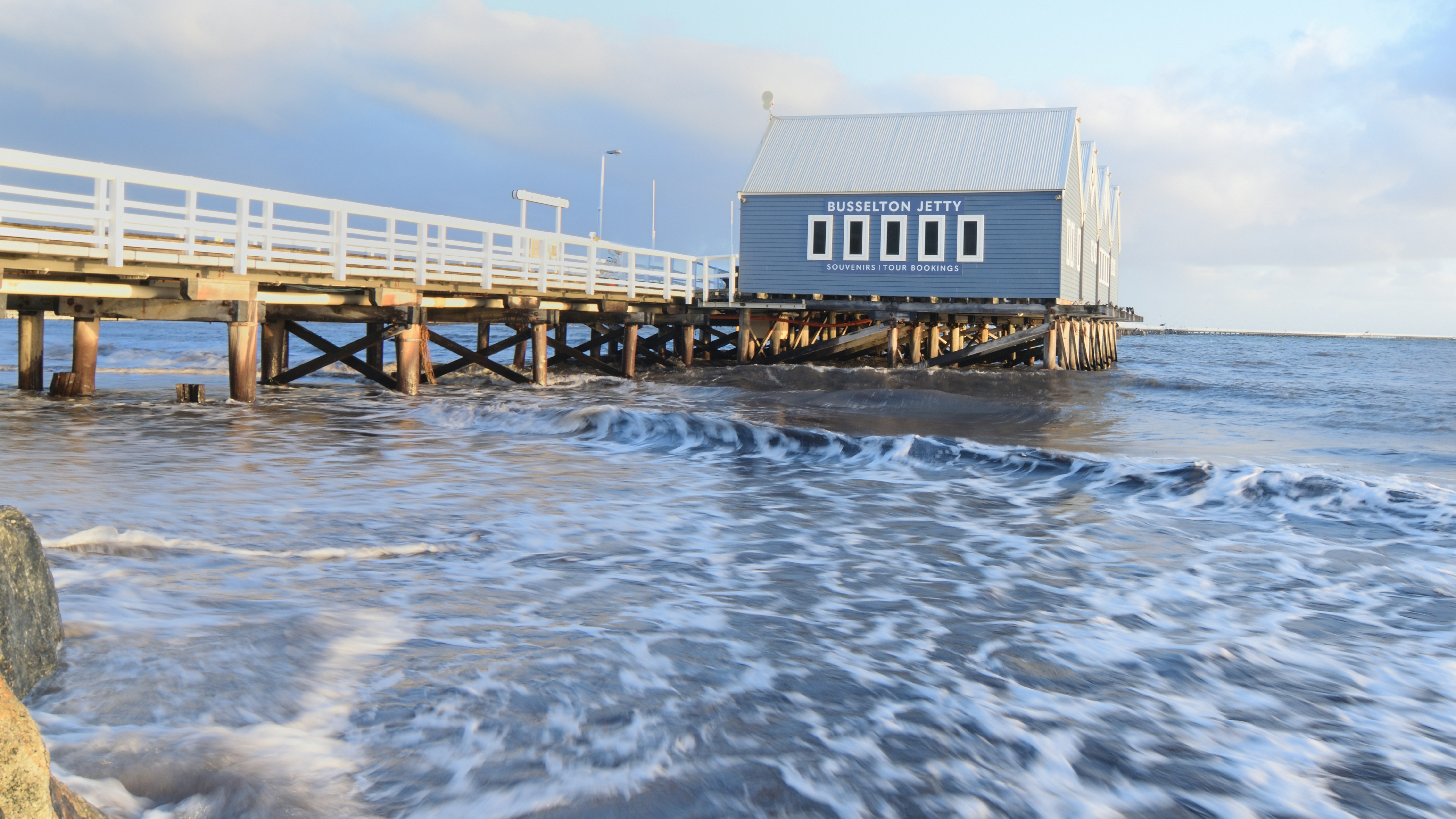 Pier of Stilled Waves: A Coastal Blue House Over Quiet Sea