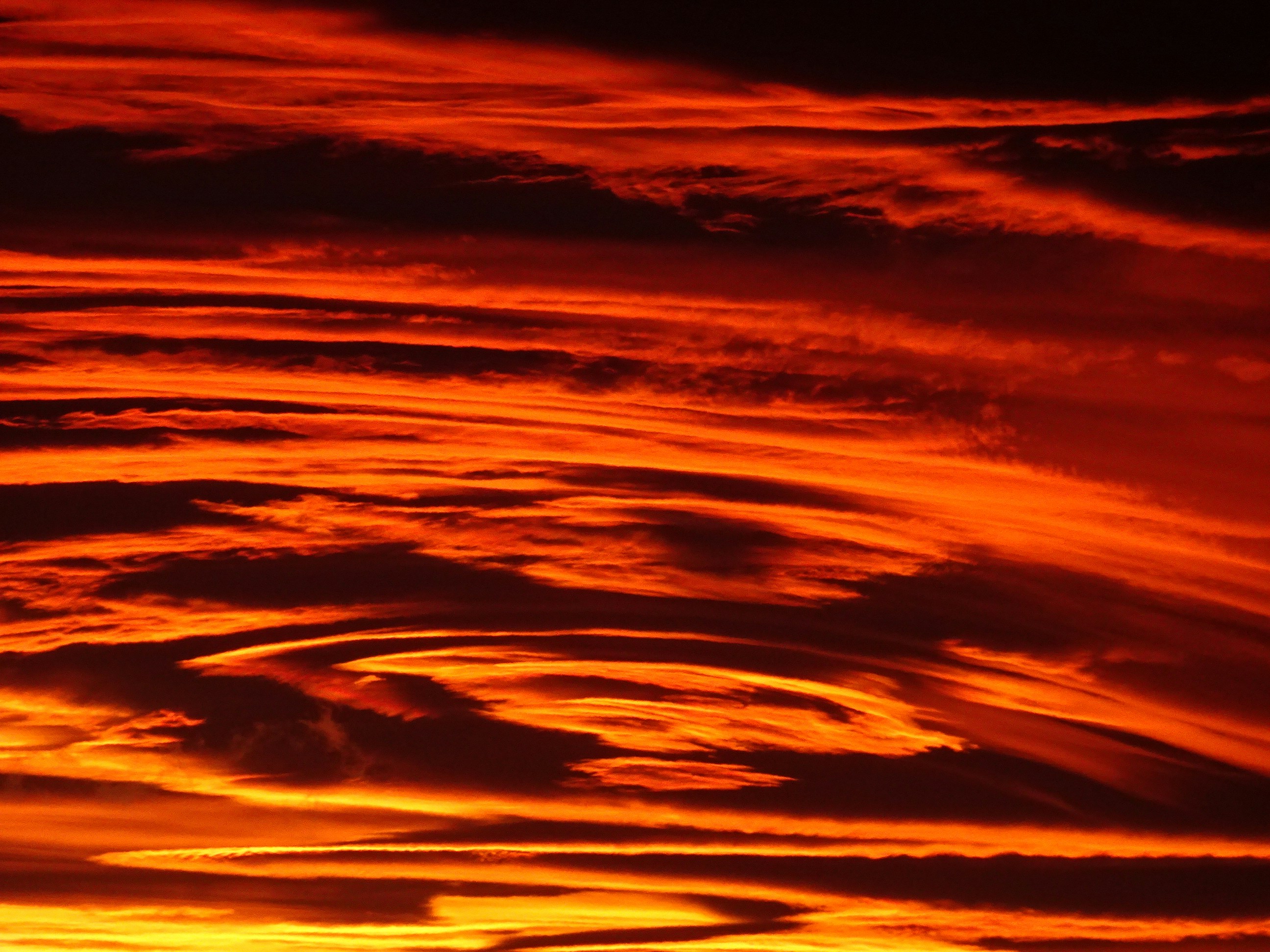 Inferno in the Sky: layered orange clouds cresting a fiery horizon