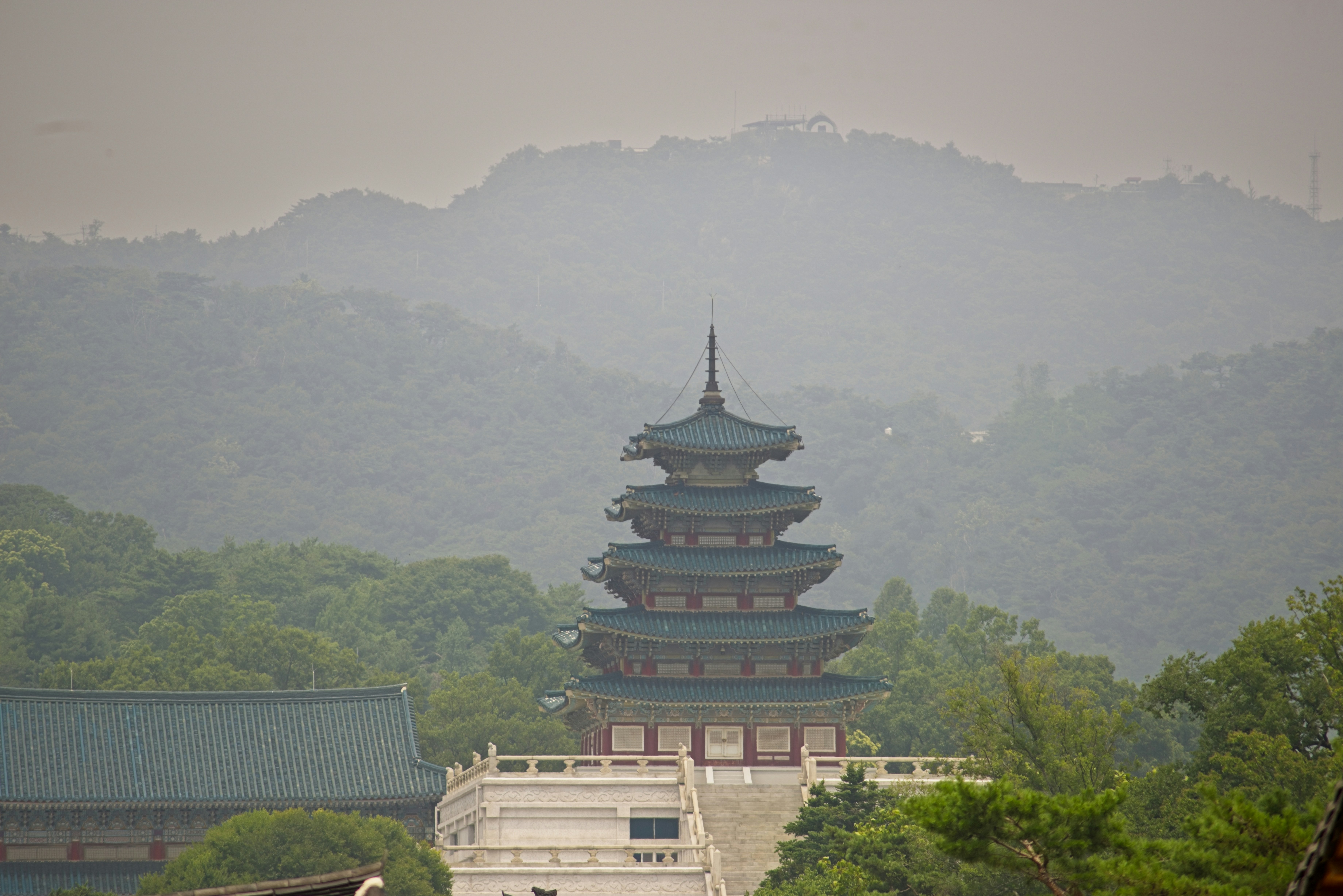 Pagoda in Mist: A Serene Temple Vista Above the Lush Ridge