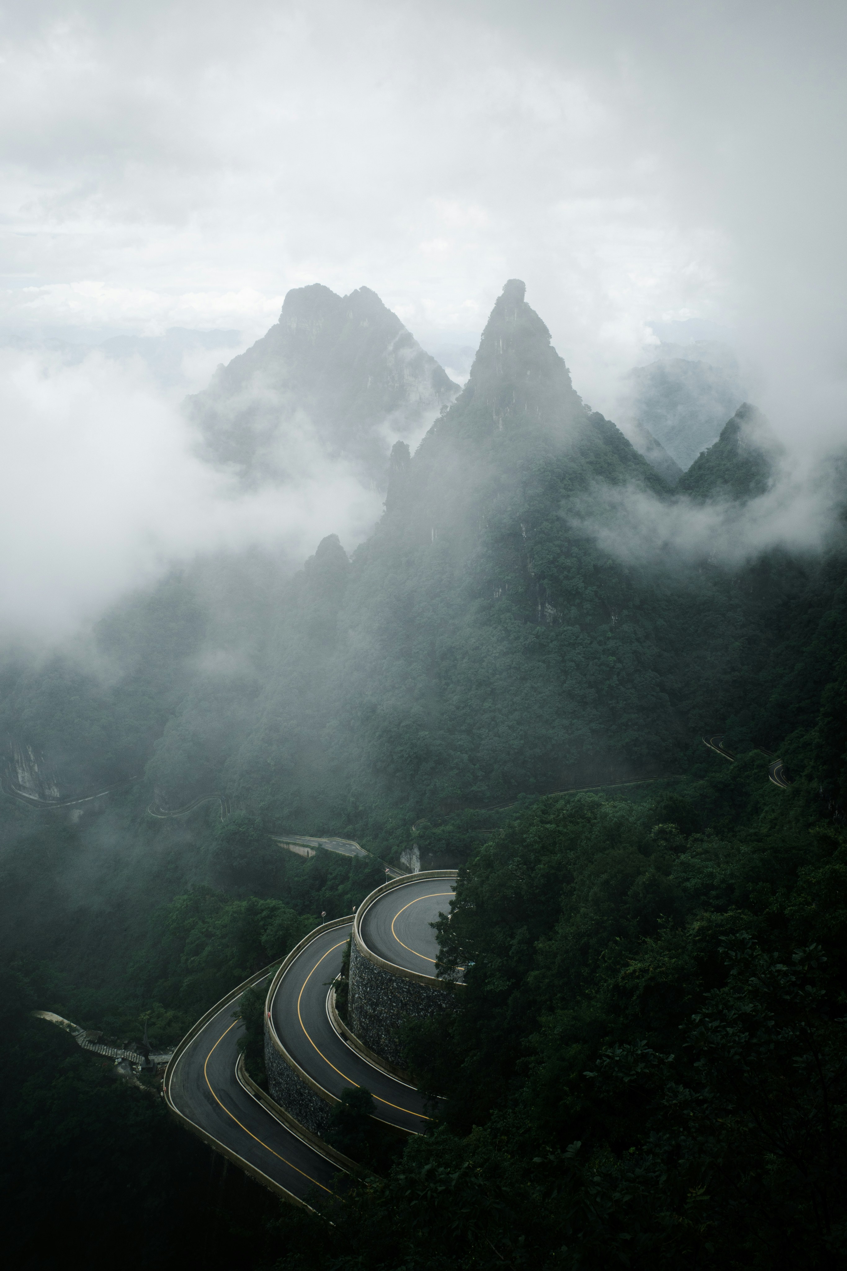 Mist-Bound Summit: A Winding Road Clings to the Mountain’s Edge