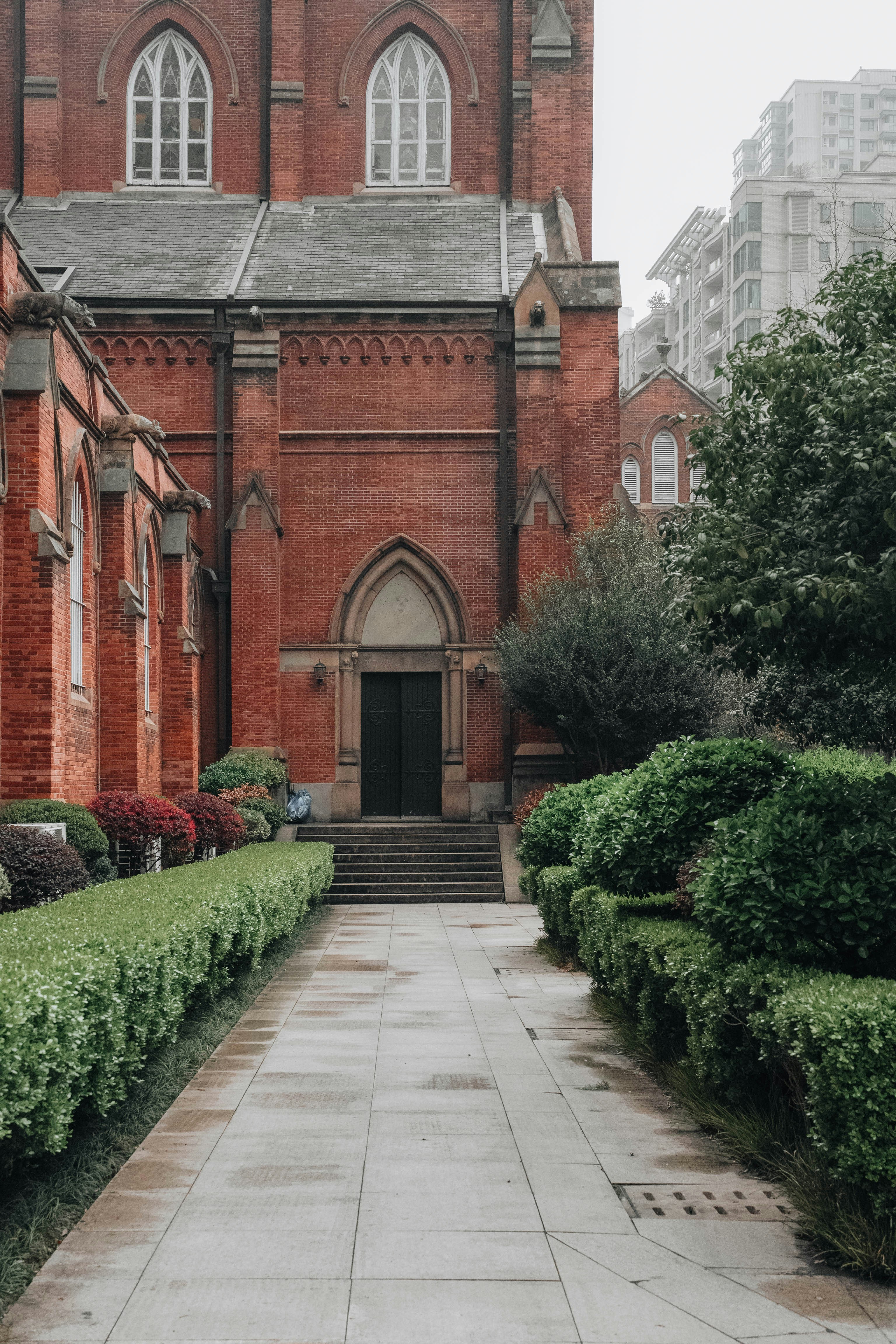 Red Brick Facade and Verdant Pathway to a Silent Door