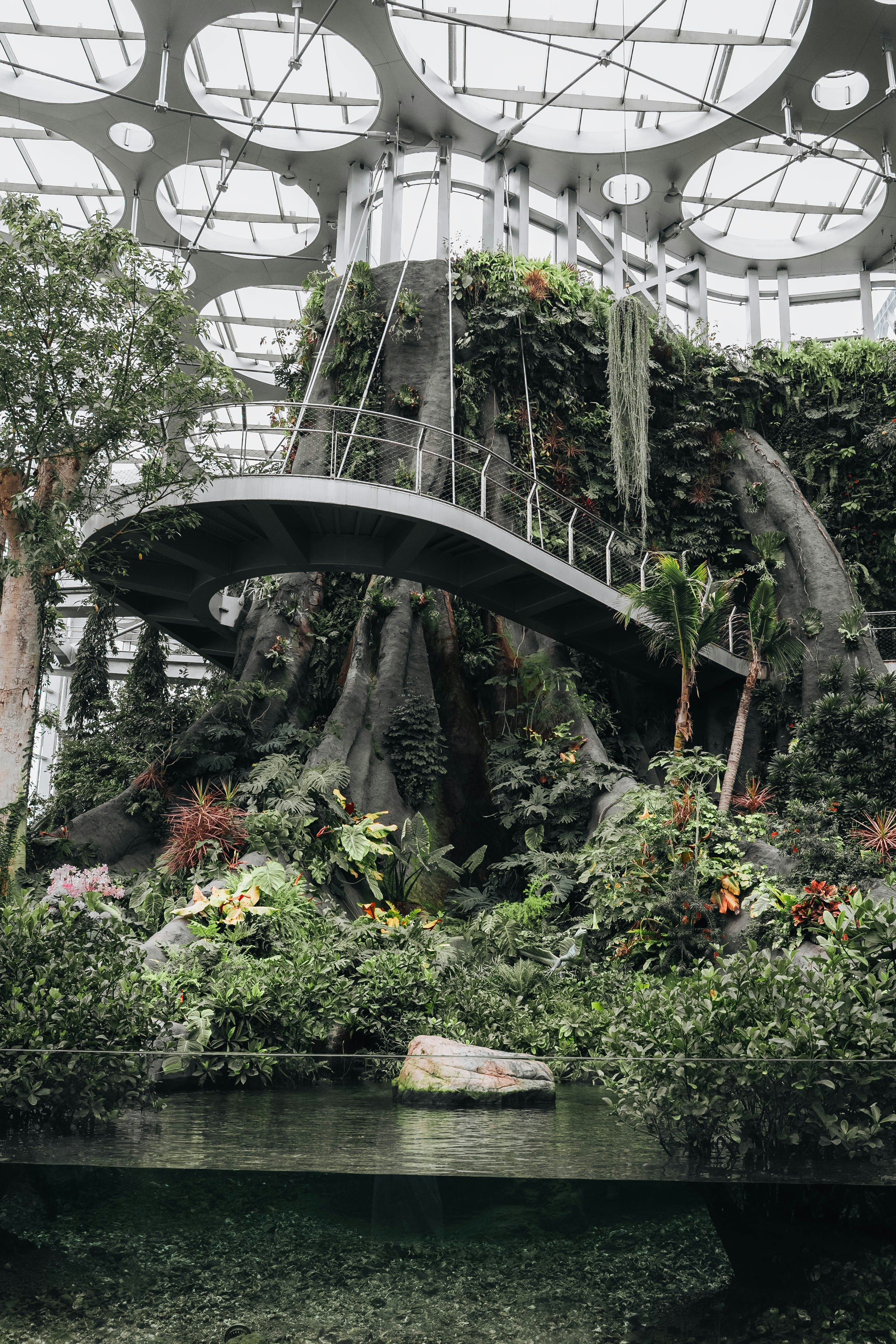Vertical Garden Cathedral: A Glasshouse Oasis with a Curved Skywalk