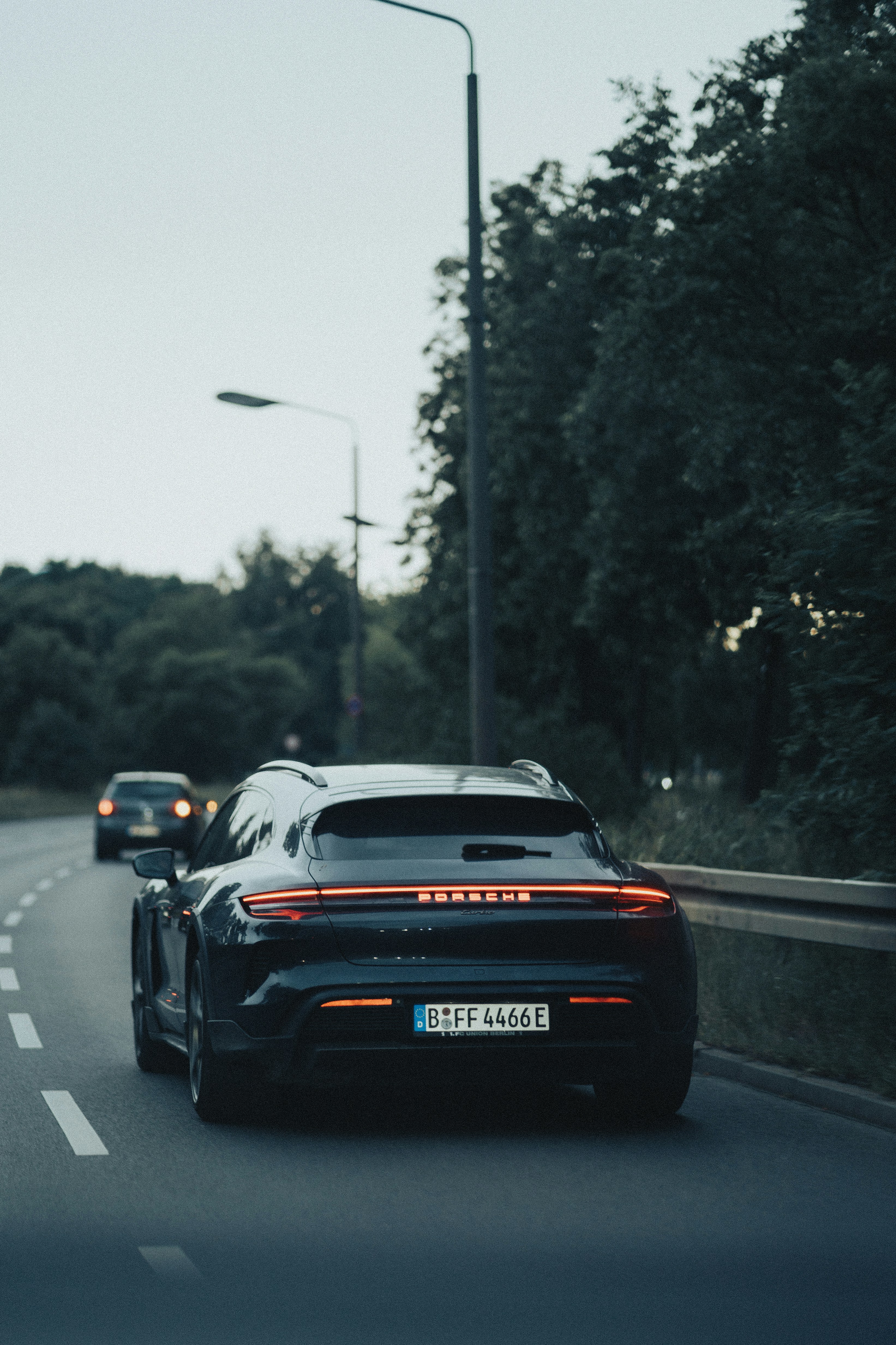 Midnight Pace: a Porsche in motion along a tree-lined highway