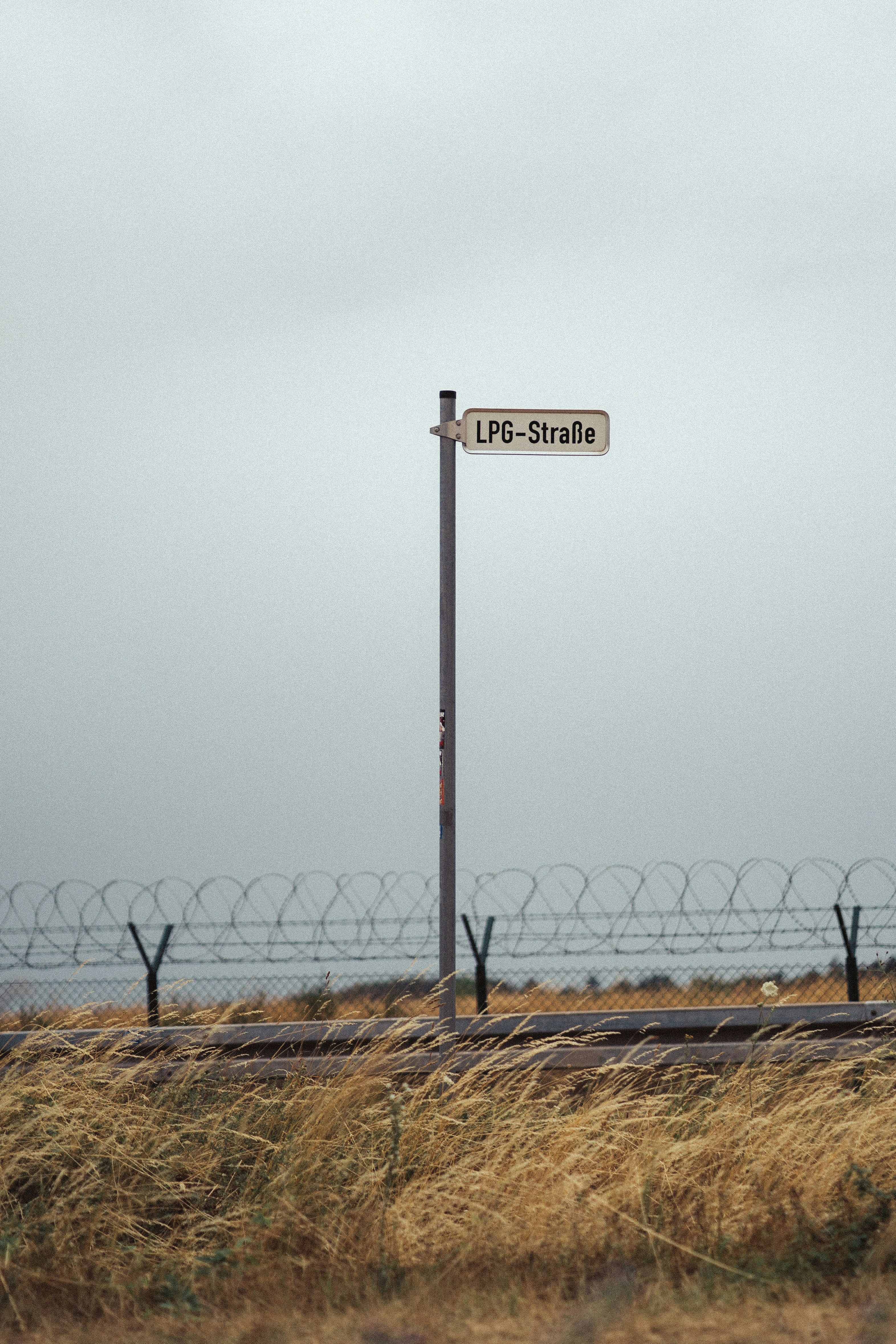 Lone LPG-Street Marker guardrail amid wind-swept grass