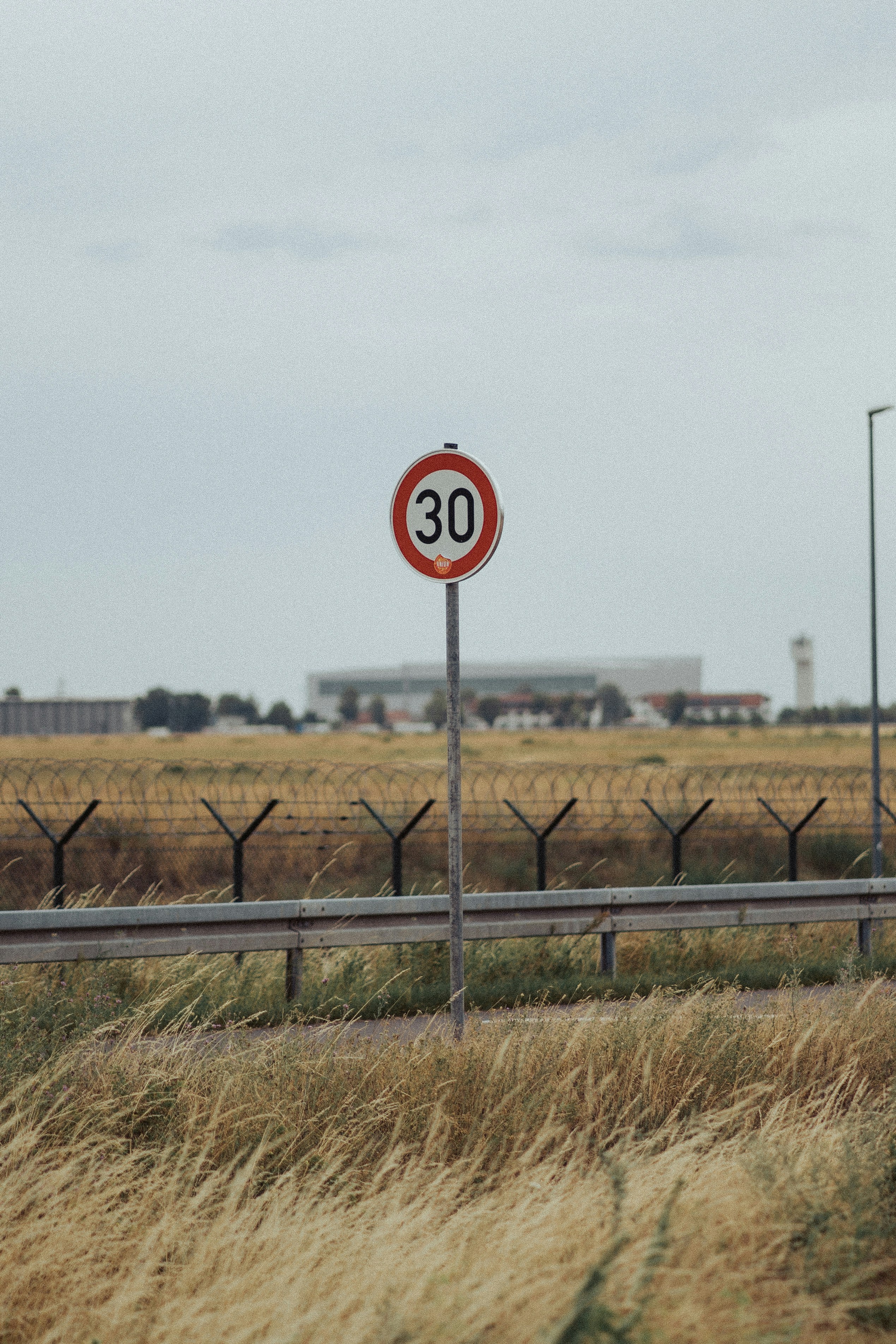 Weathered Road Sign Guarded by Open Field