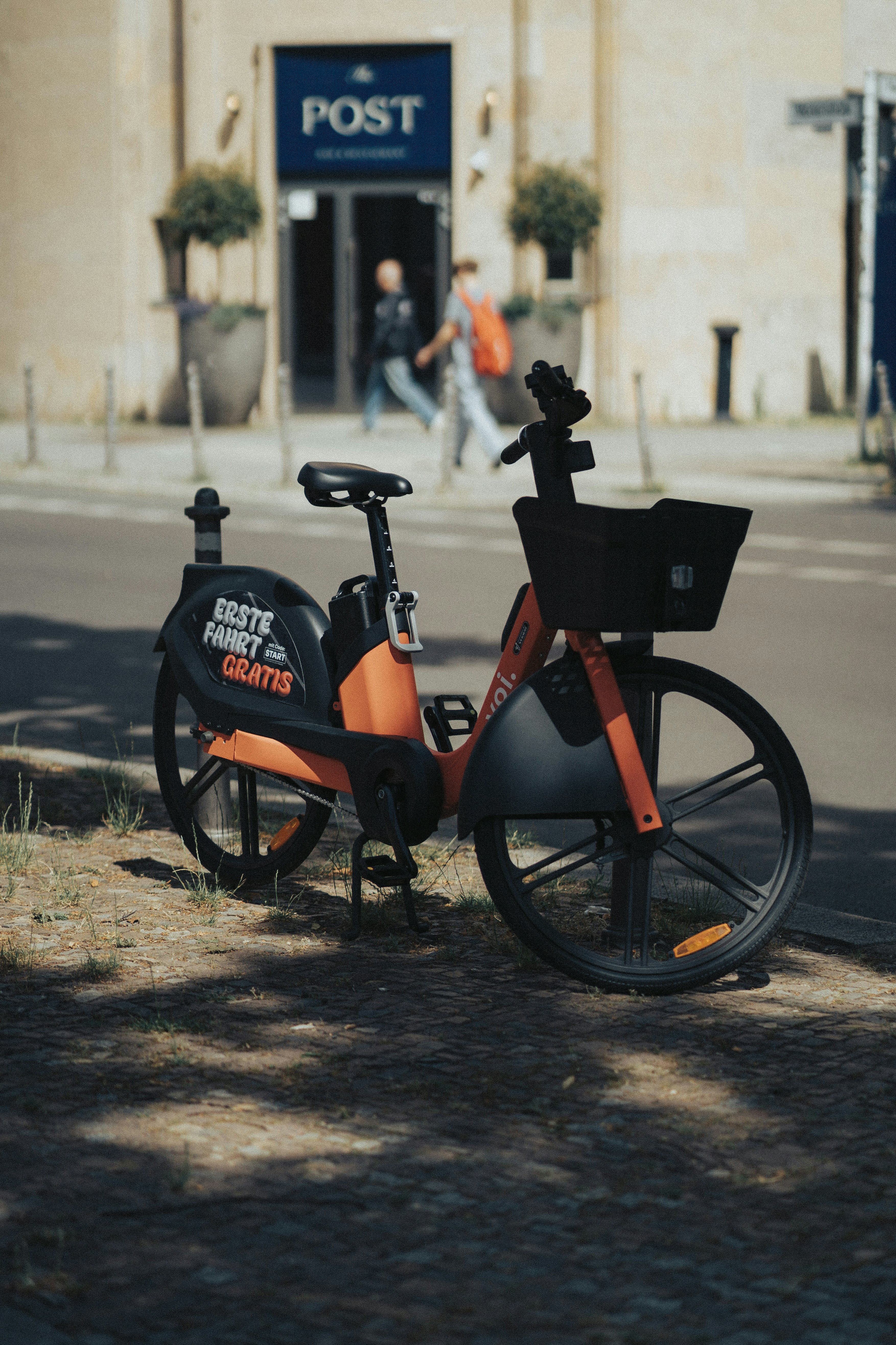 Urban Courier: A Bright Orange Bike Anchored on a Quiet Street
