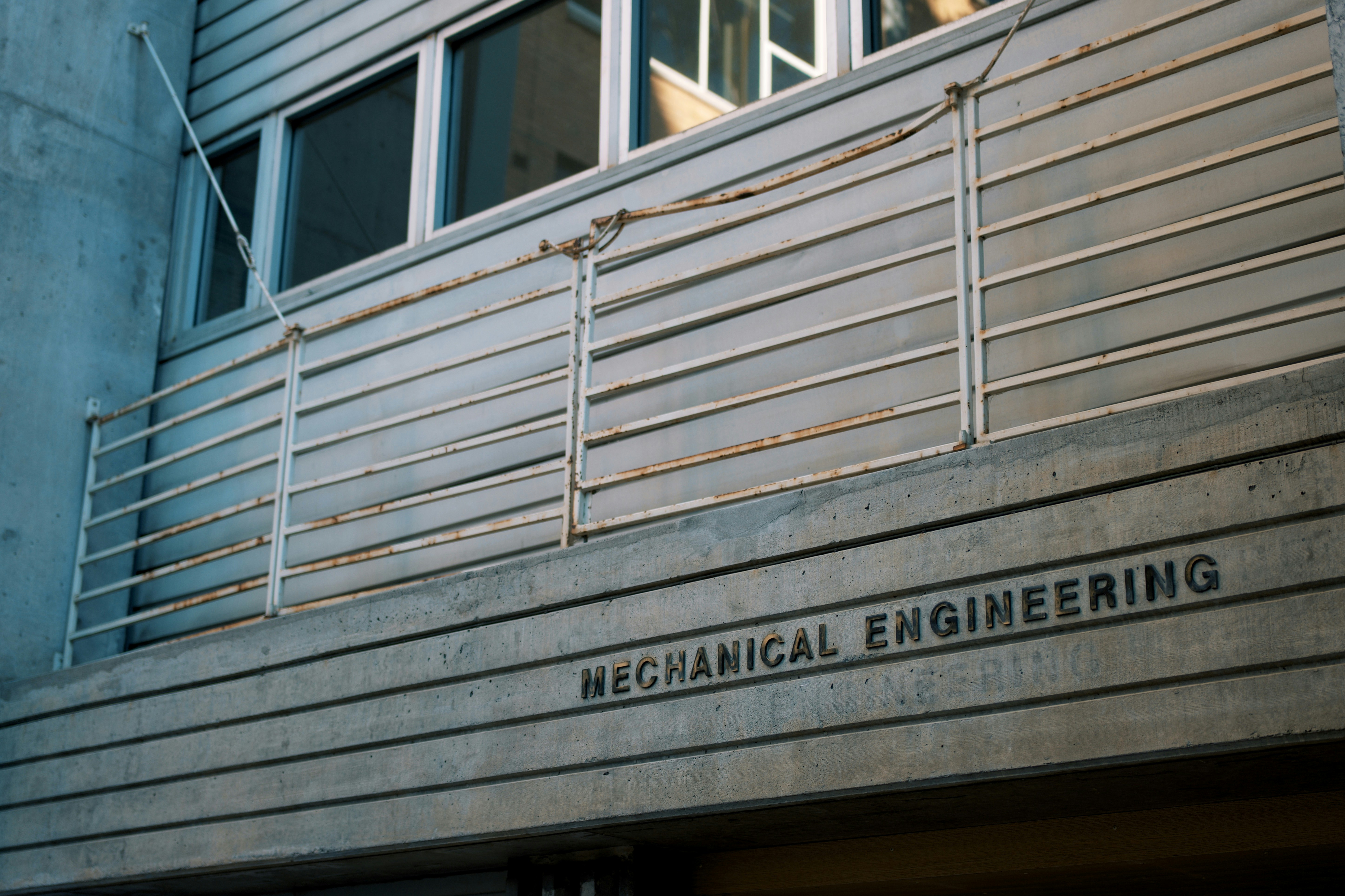 Concrete Facade, Mechanical Engineering Sign, and Weathered Railings