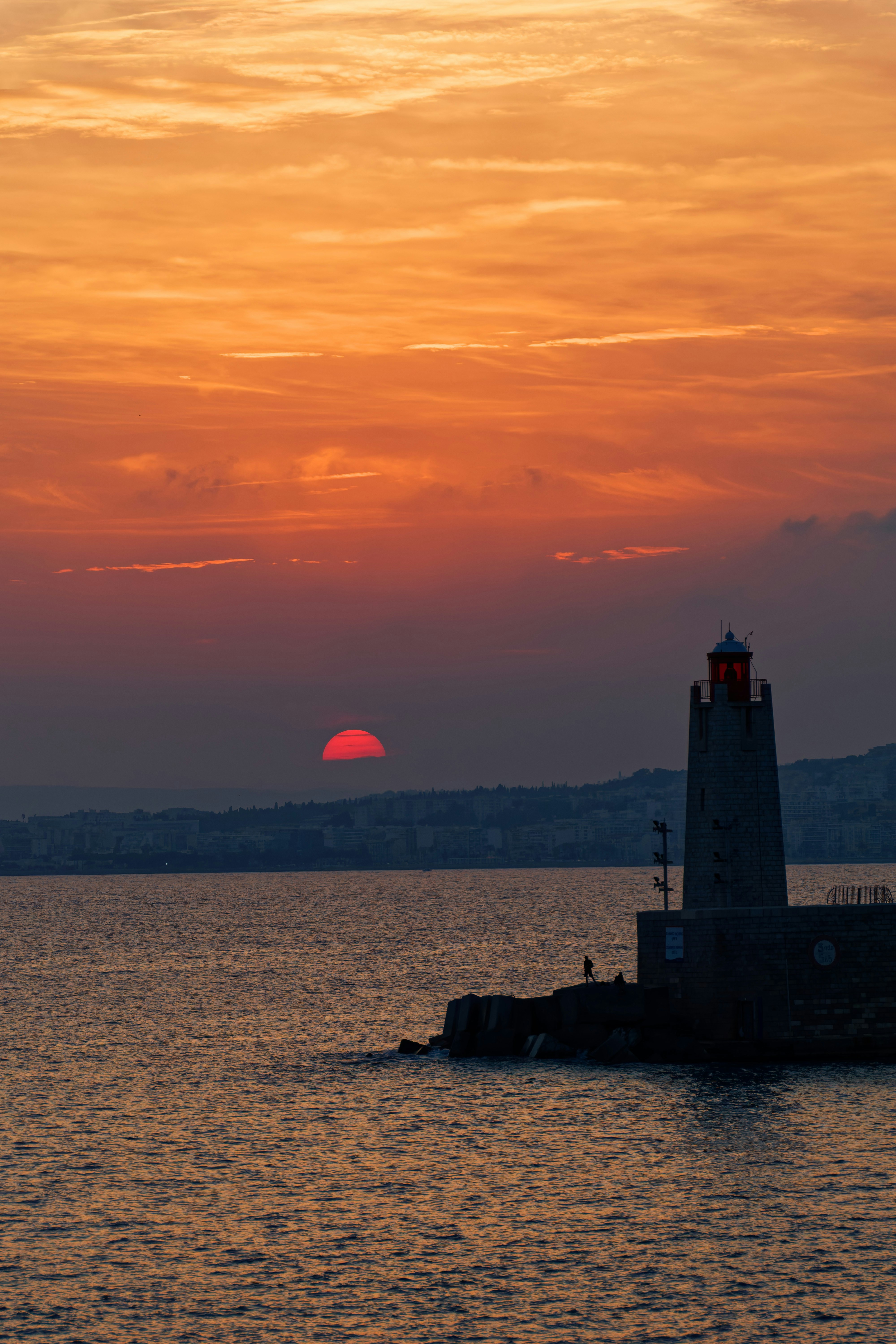 Red Sun on the Horizon by the Lighthouse