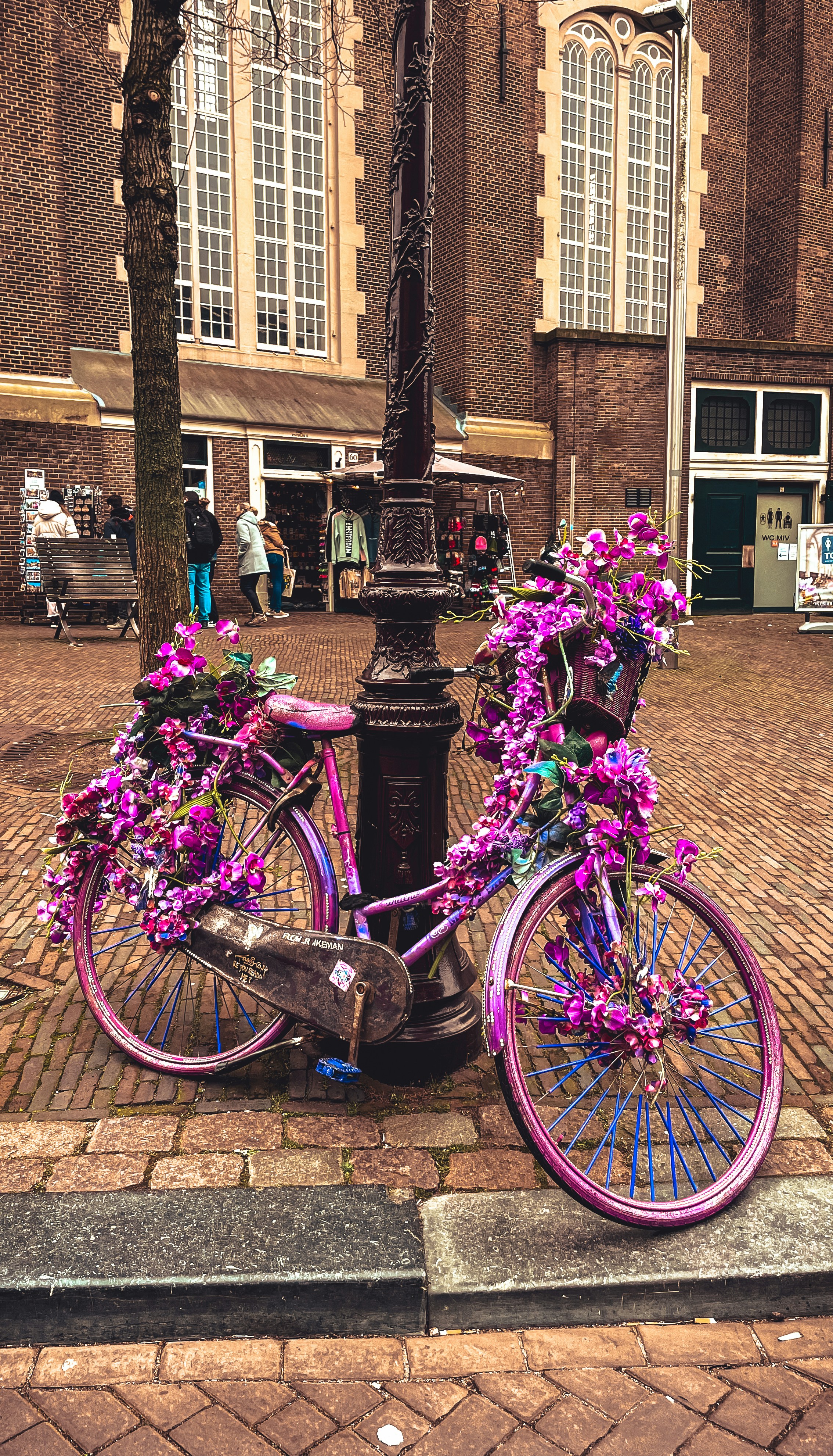Floral-Bedecked Bike by a Historic Brick Facade