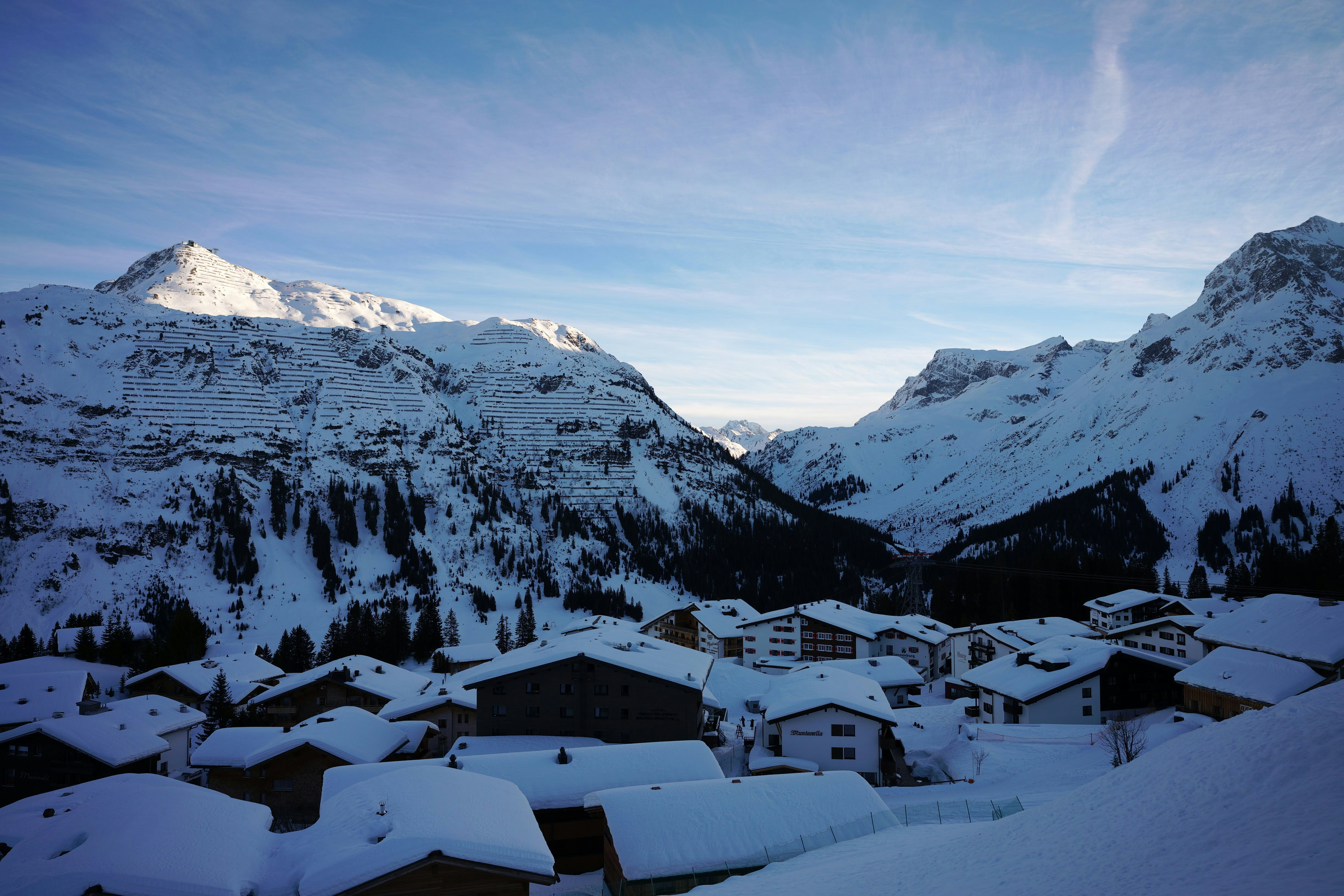 Snowbound Village Nestled Between Alpine Rorges at Dusk