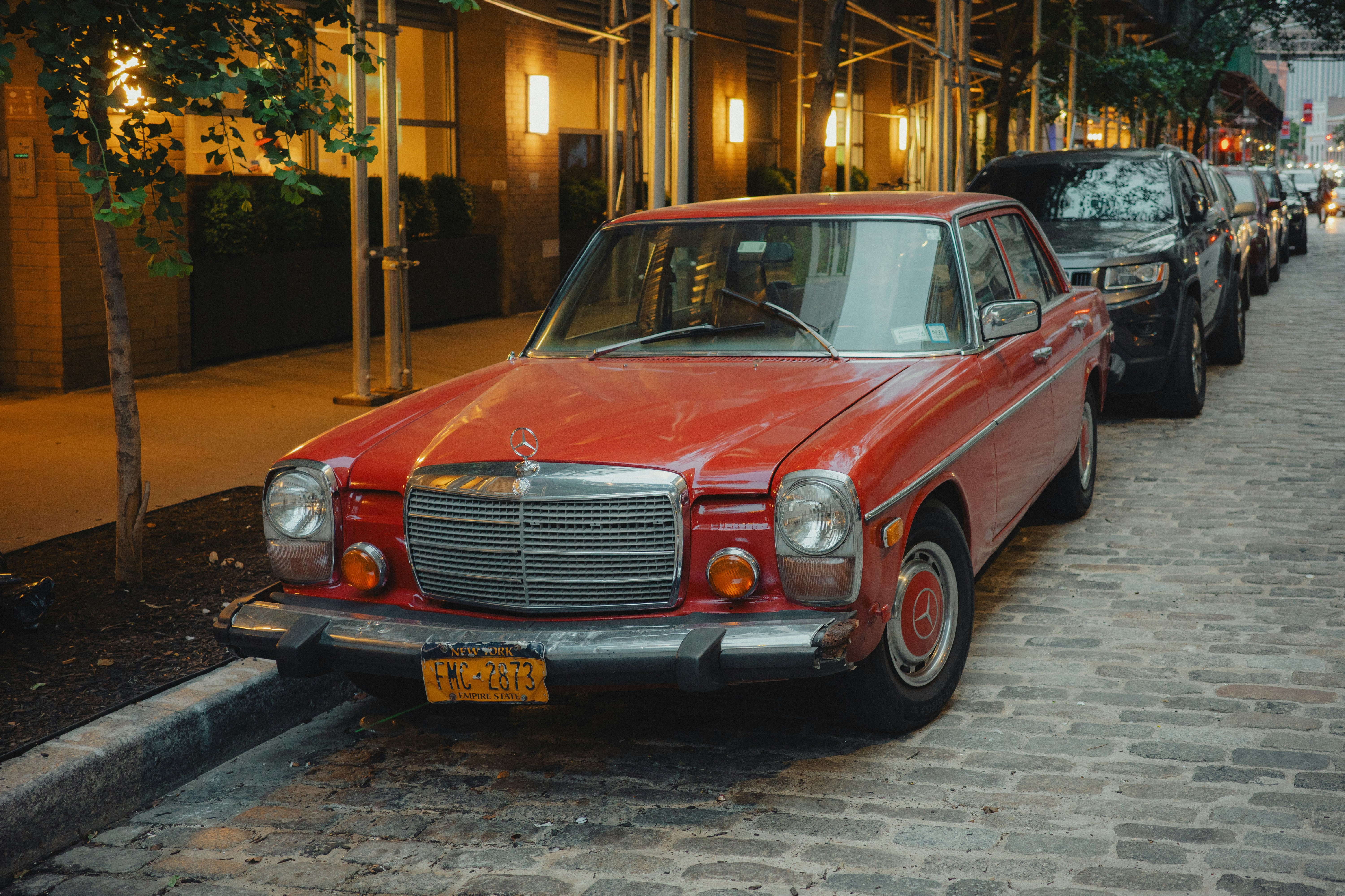 Vintage red Mercedes on a rainy urban cobble row