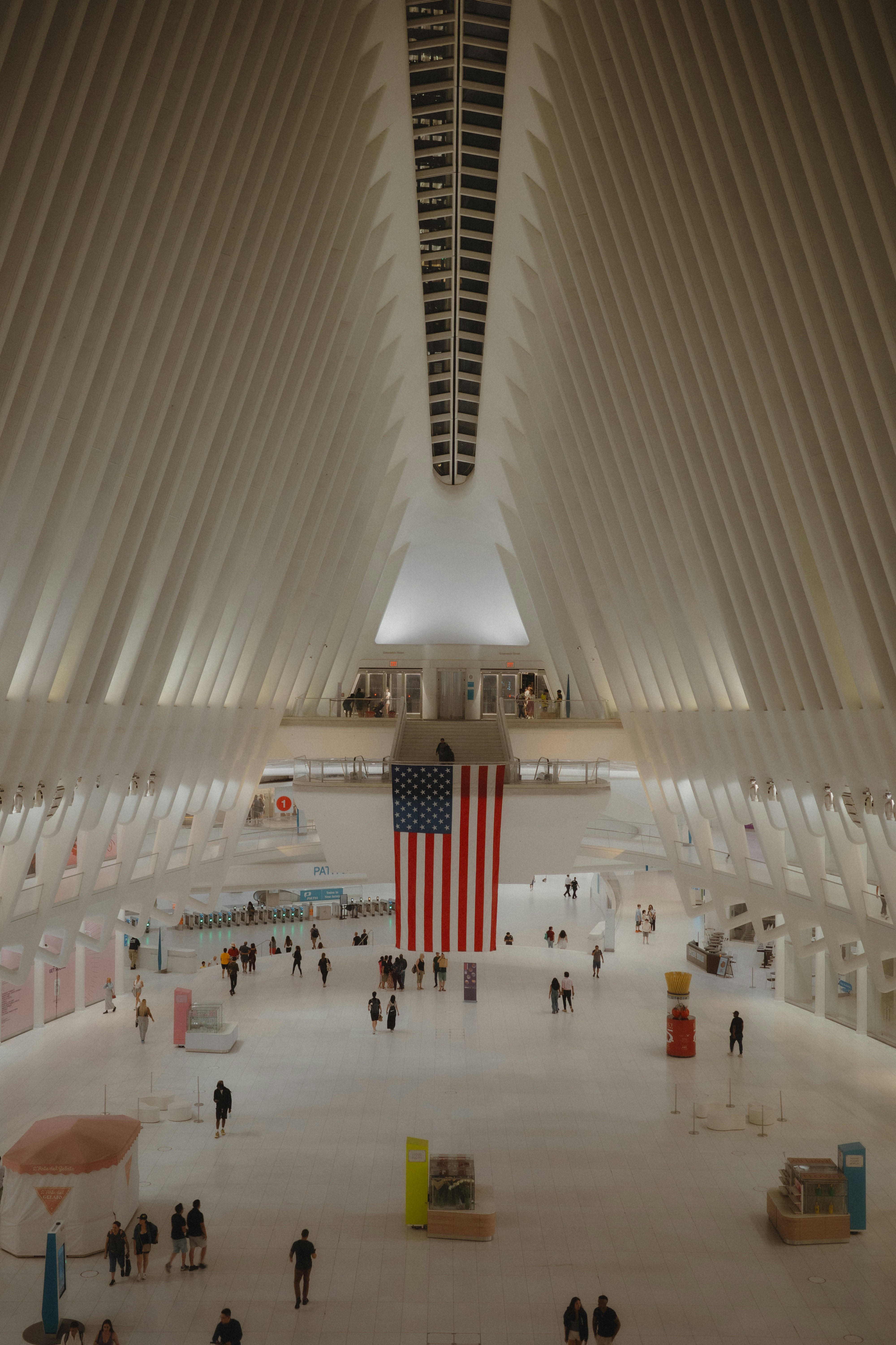 American flag suspended in the cathedral-like concourse of a modern transit hub