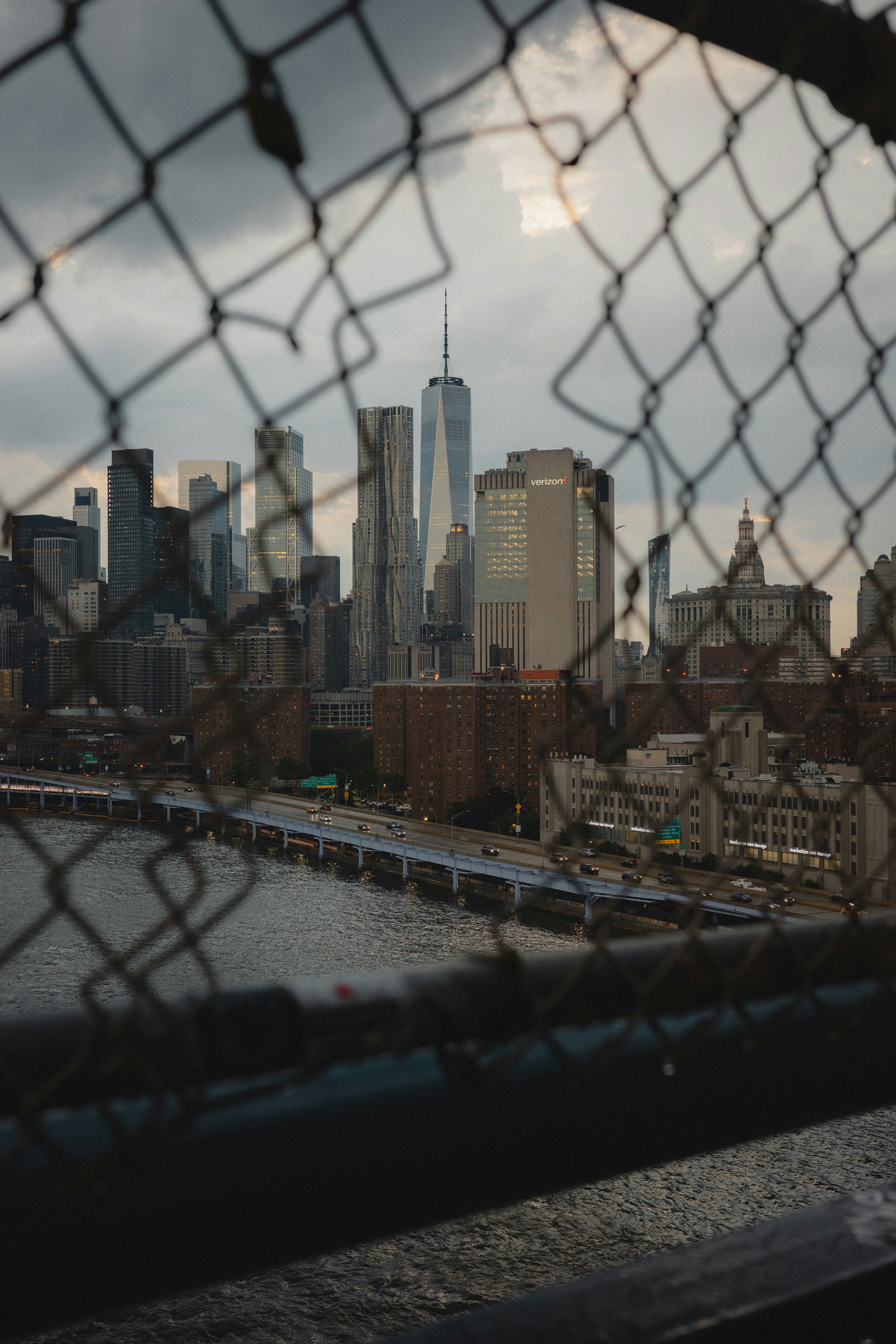 City Lights Beyond Chainlink: A Fence-Framed Skyline