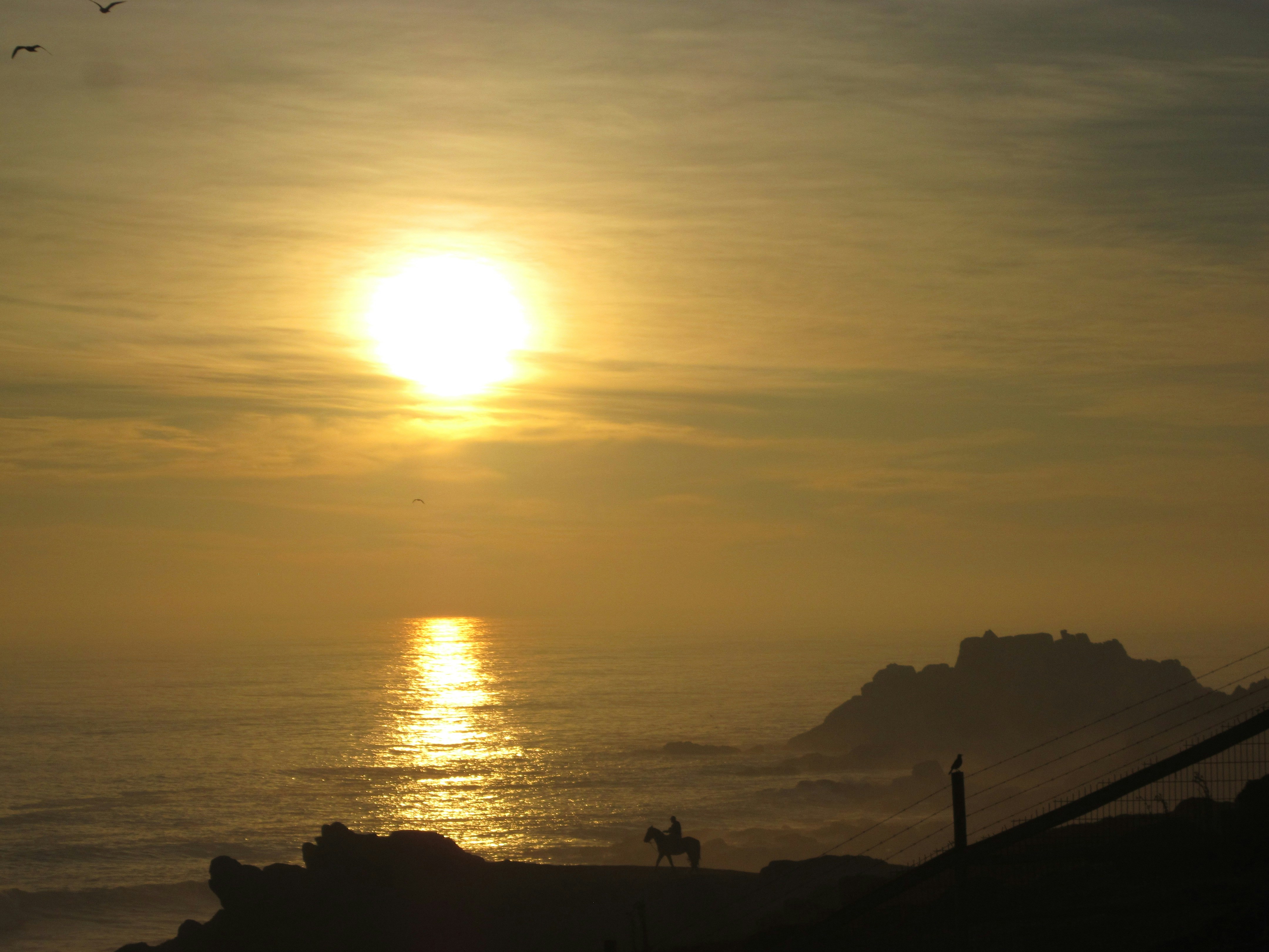 Sunlit Horizon: Riders and Rock silhouettes at Dusk