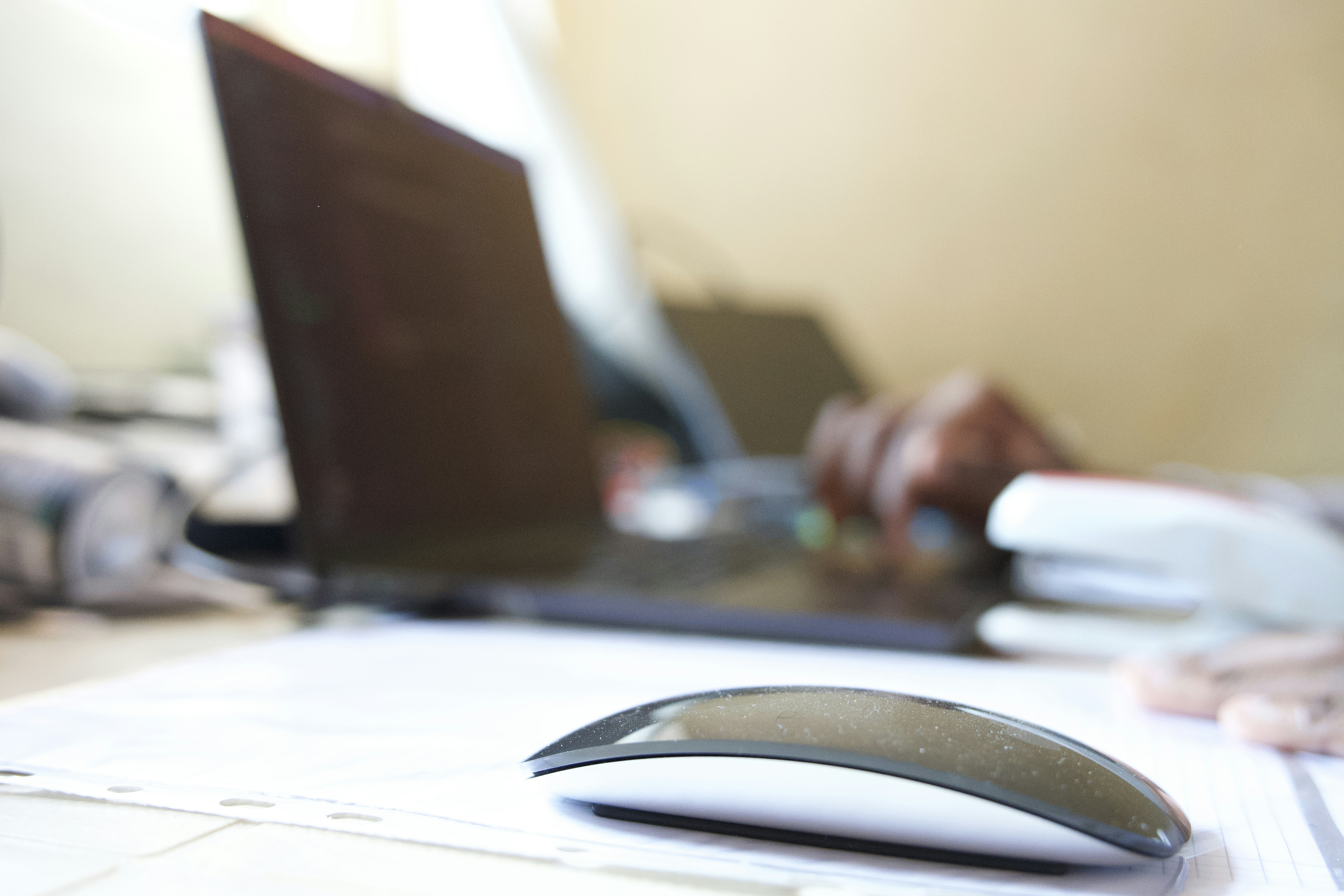 Deskside Focus: Wireless Mouse in the Foreground with a Blurred Office Scene