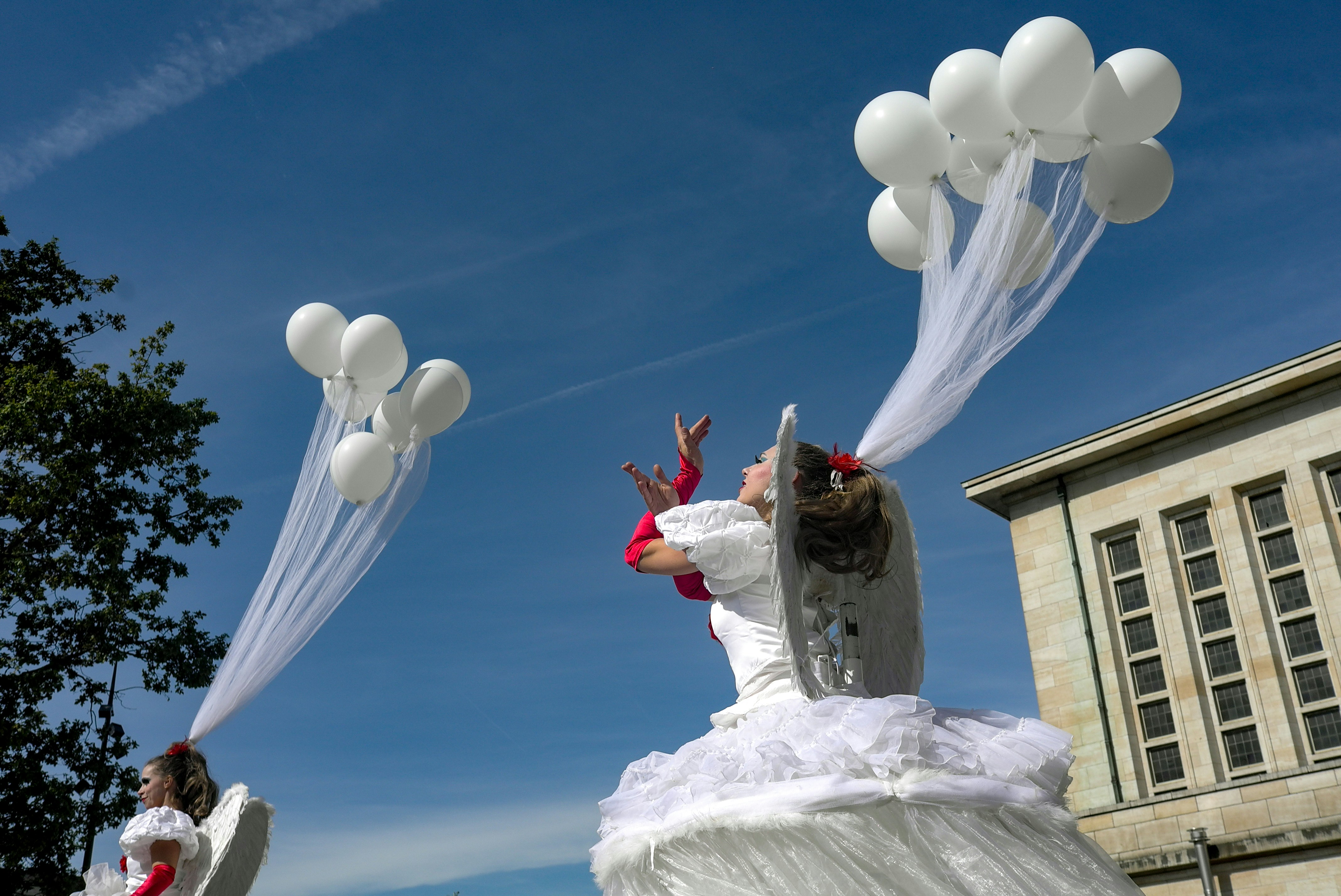 Bride on a Whimsical Ascent: Balloons and Bold White Gown