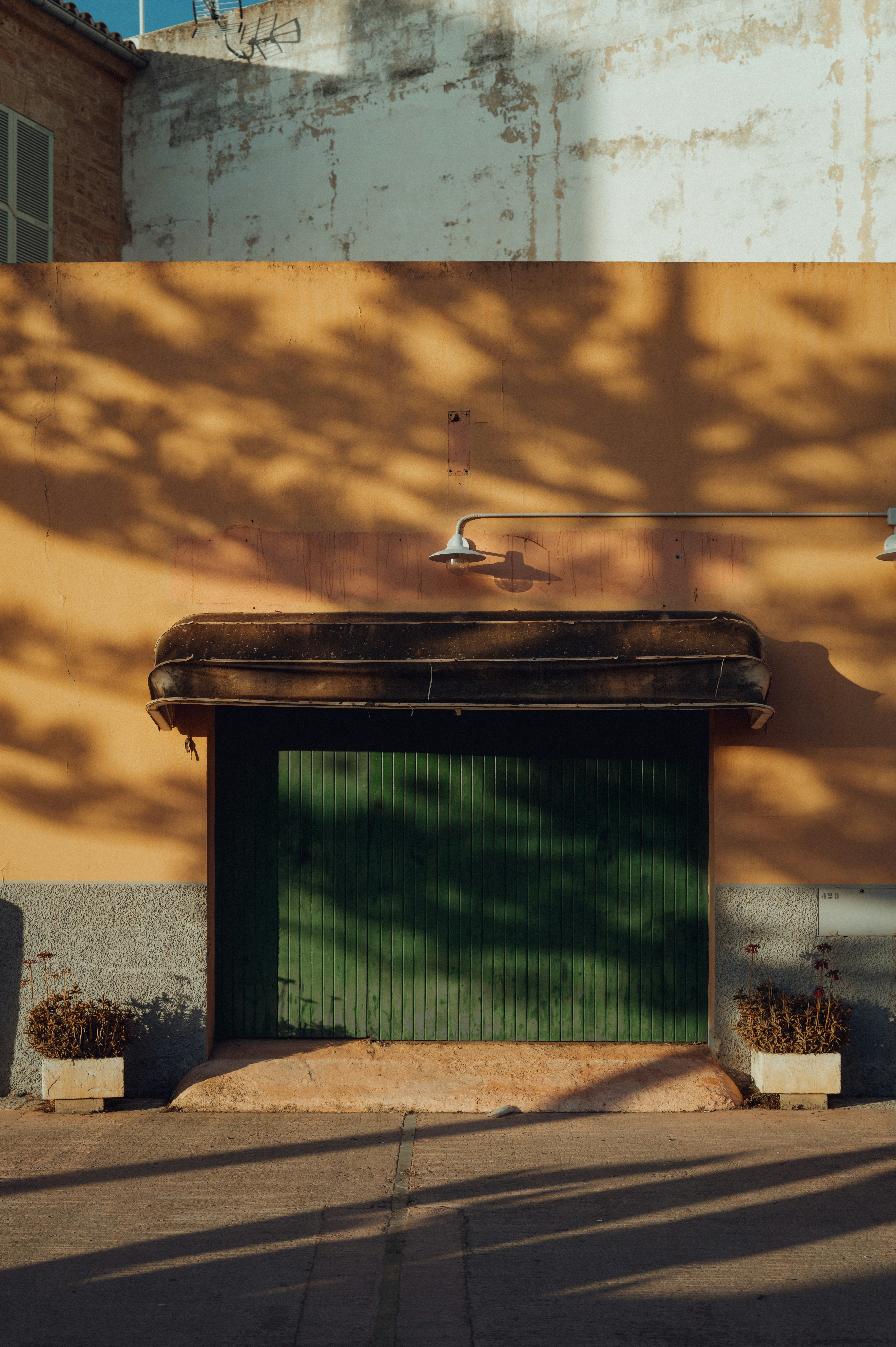 Sunlit Orange Facade Beneath the Green Garage Door