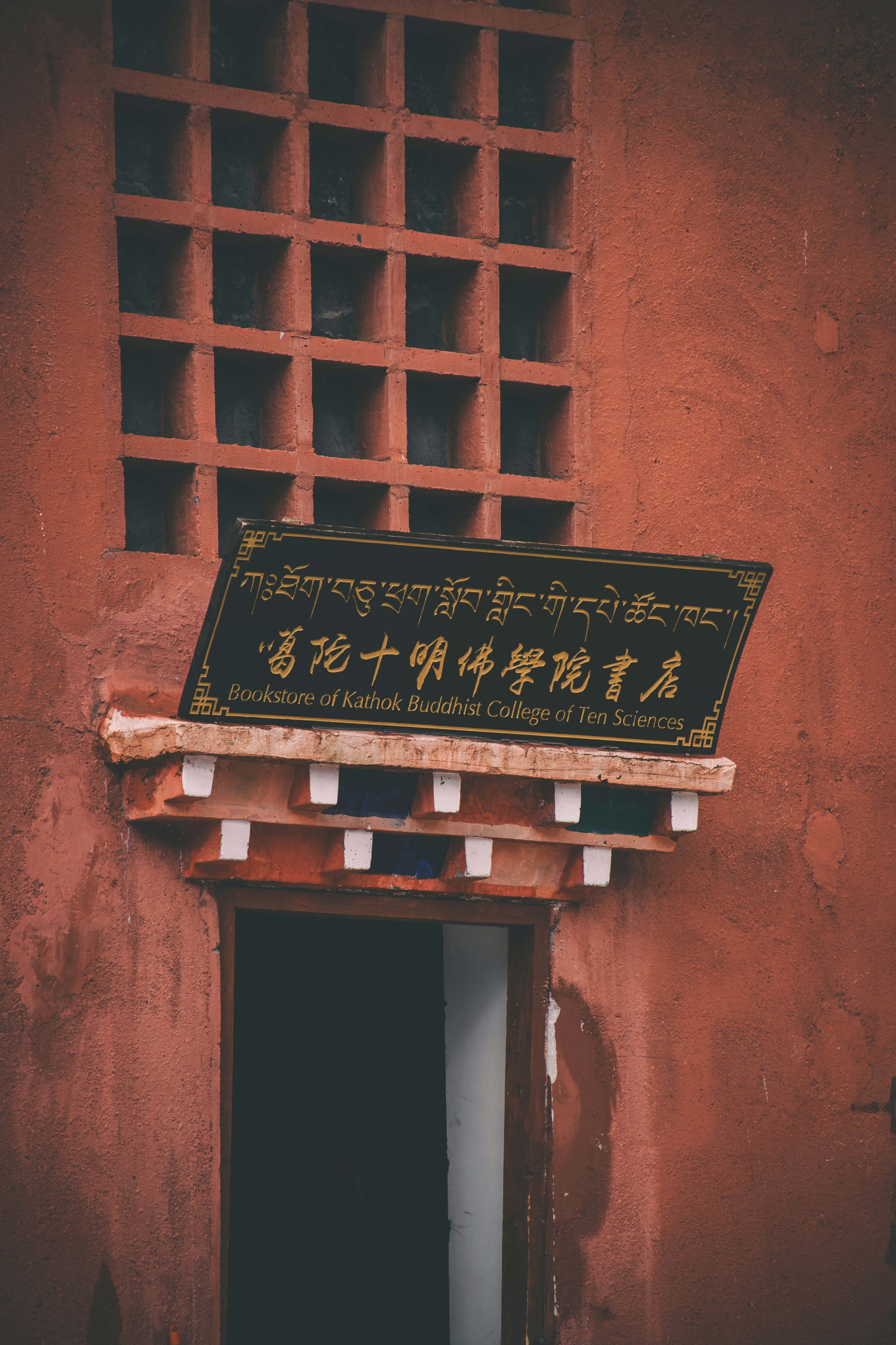 Red Terracotta Facade and Signage: A Quiet Threshold of a Buddhist Bookstore