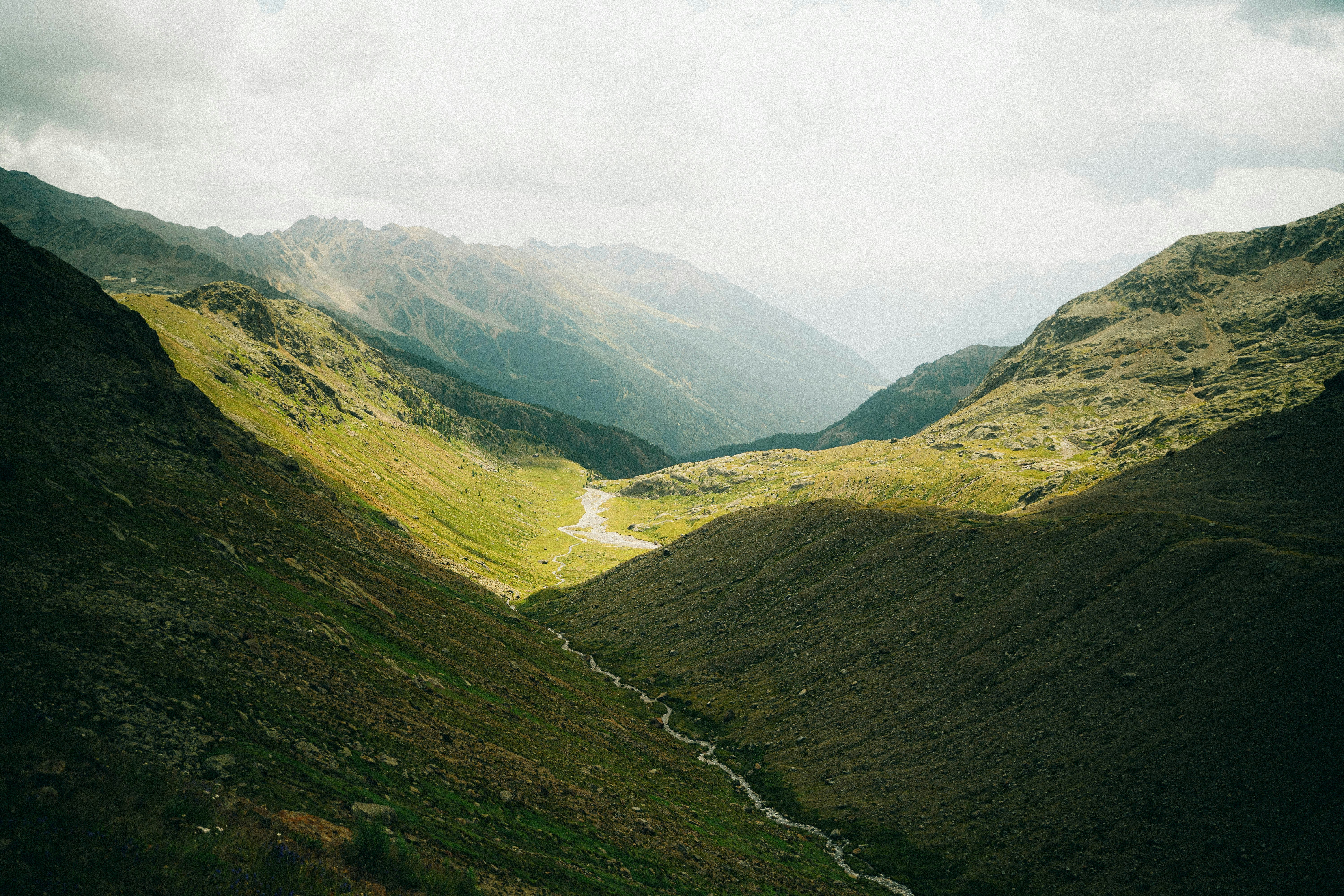 Vast Valley Dawn: A Winding Creek Through Verdant Slopes