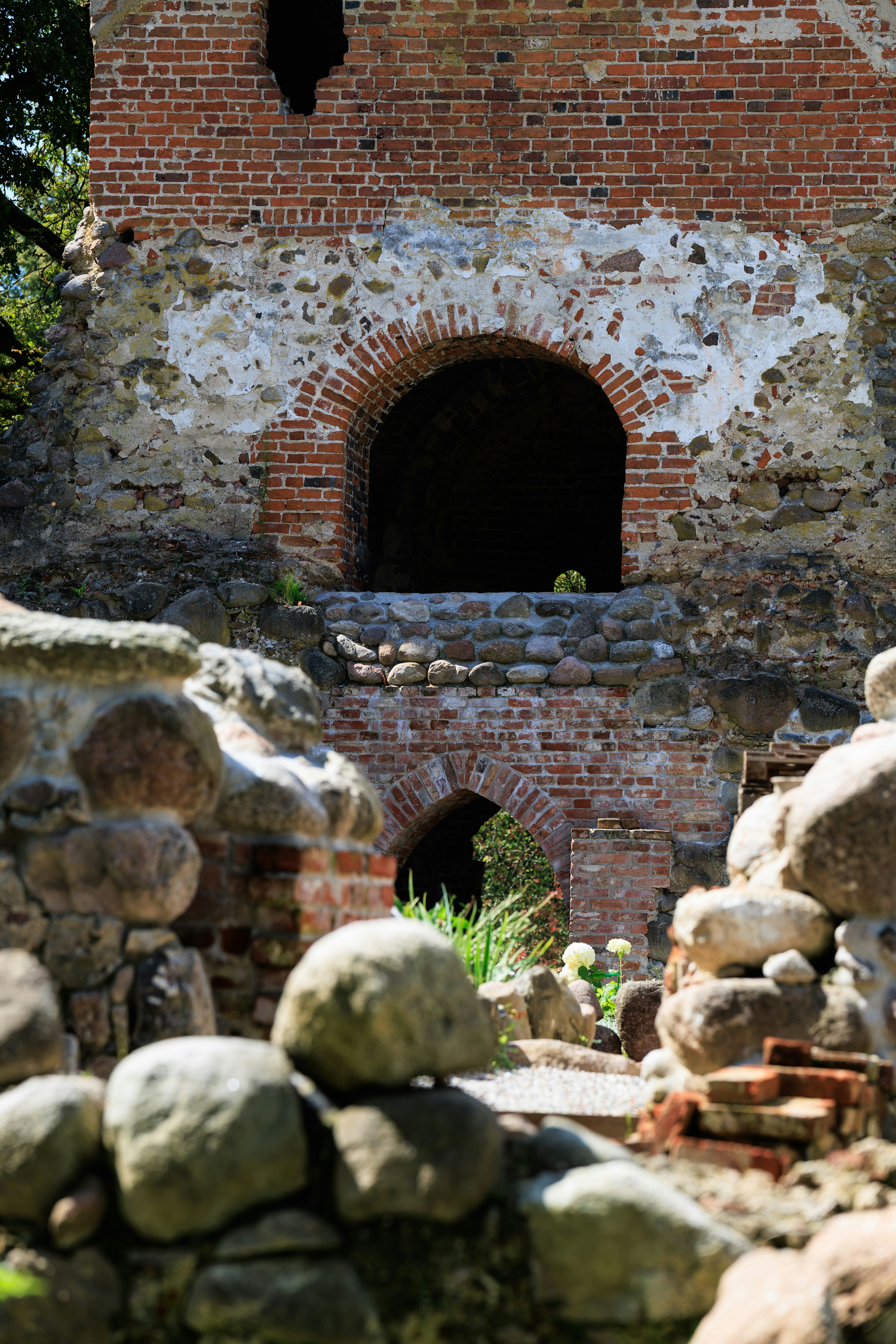 Ruined Brick Archway framed by stonework and greenery