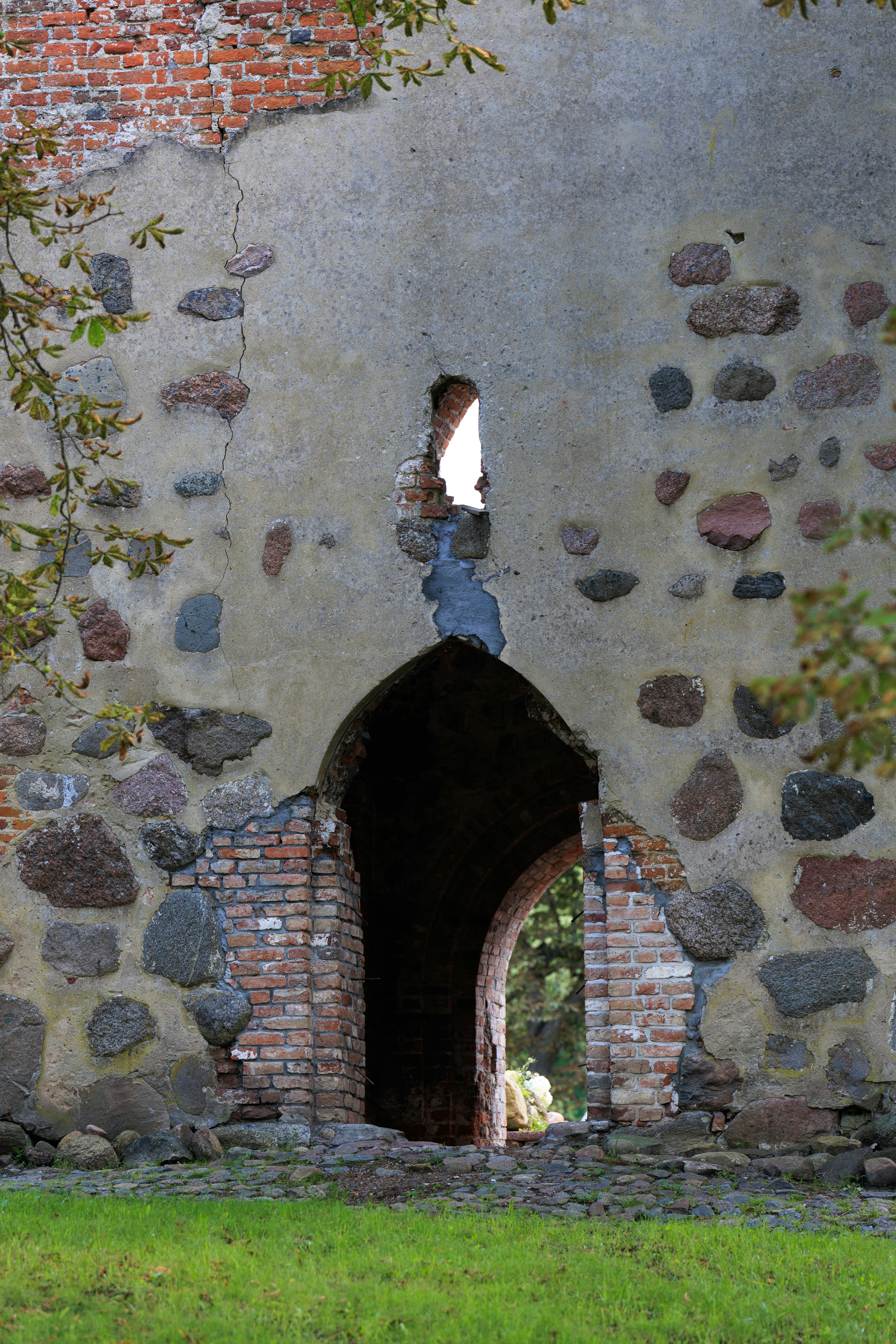 Stone Archway with Slender Walled Passage Framed by Verdant Edge