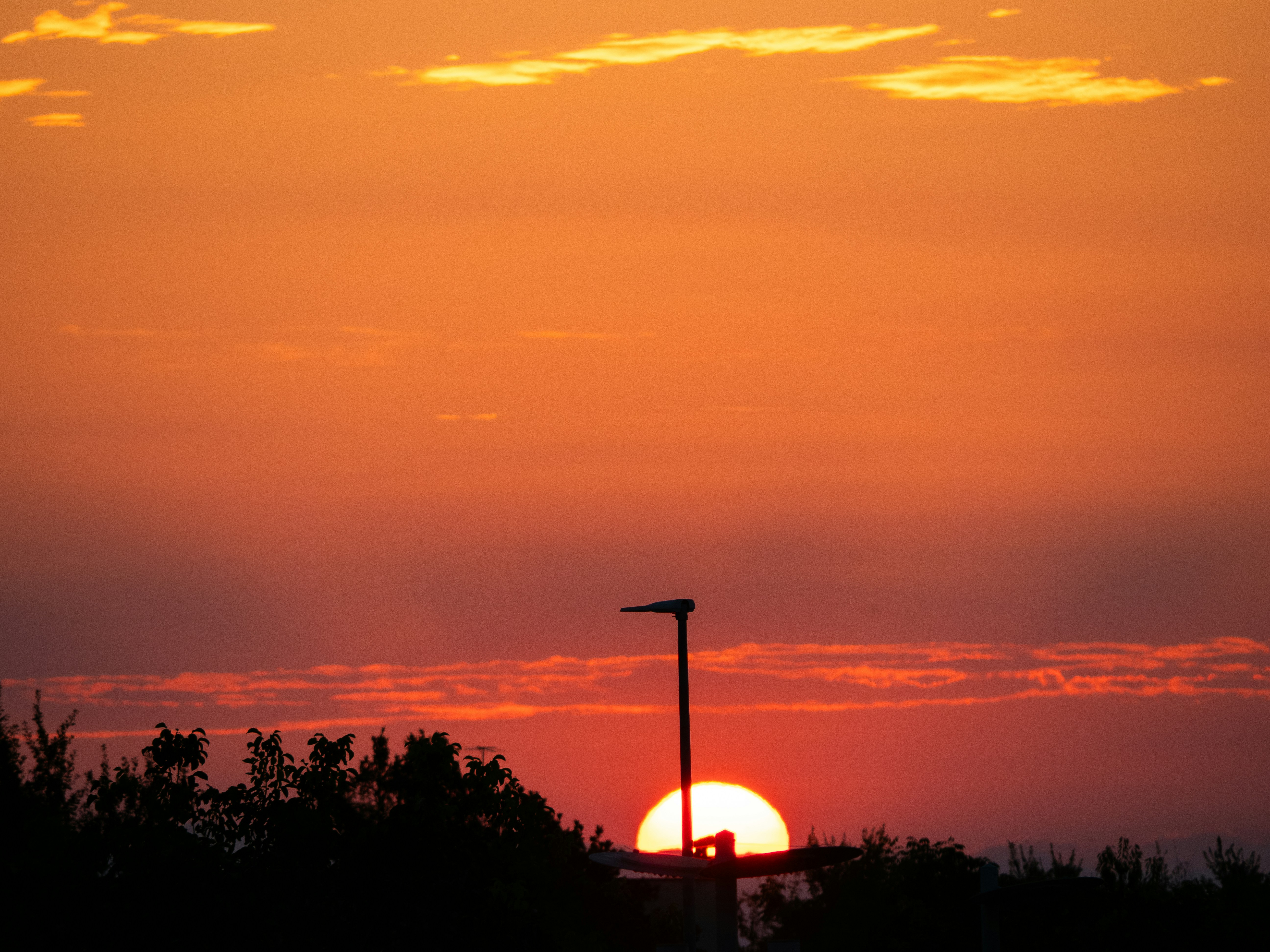 Sunset Silhouette: A Streetlamp Quietly Guarding the Horizon
