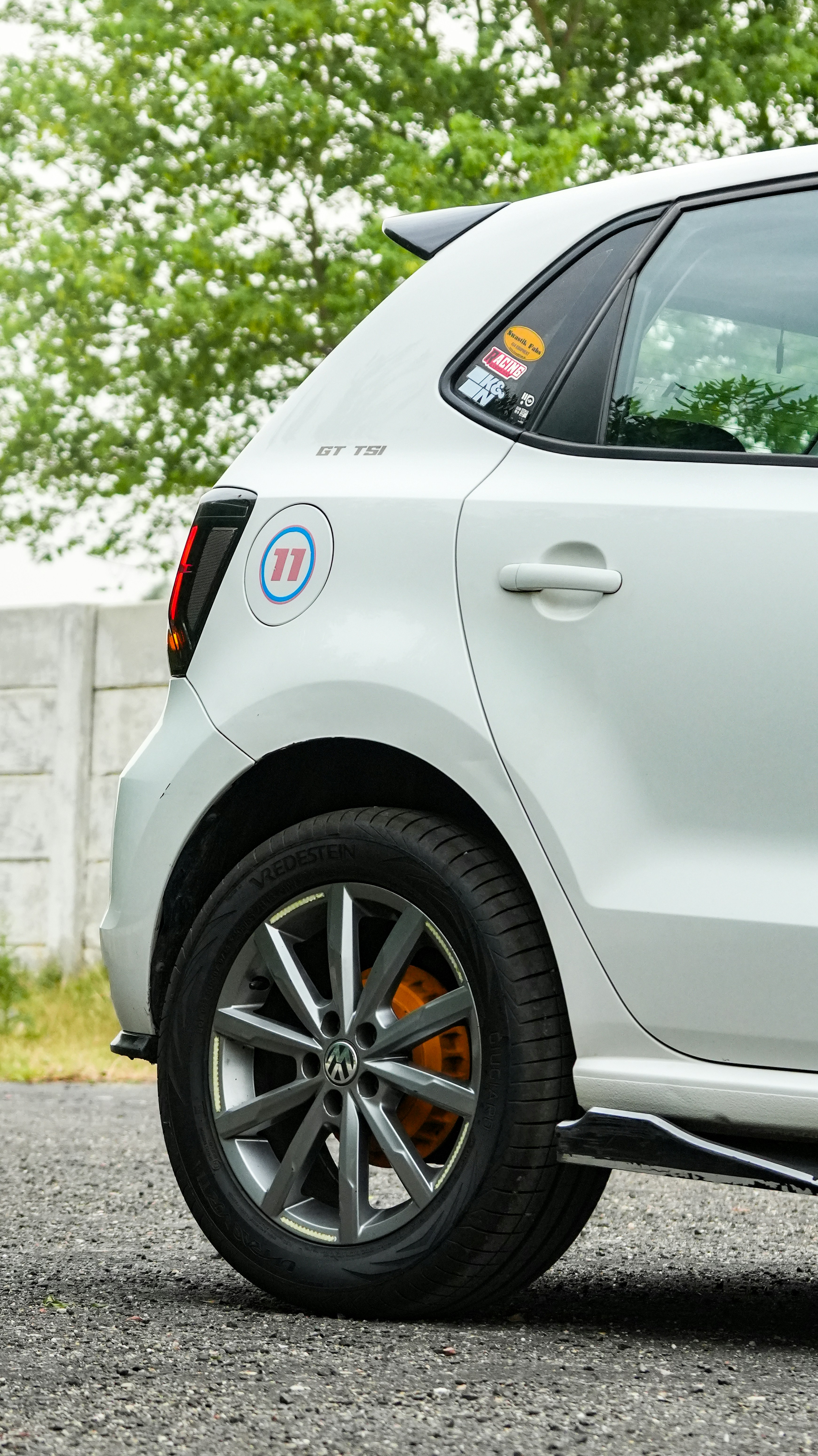 White compact hatch with vibrant orange brake calipers and chrome side skirt
