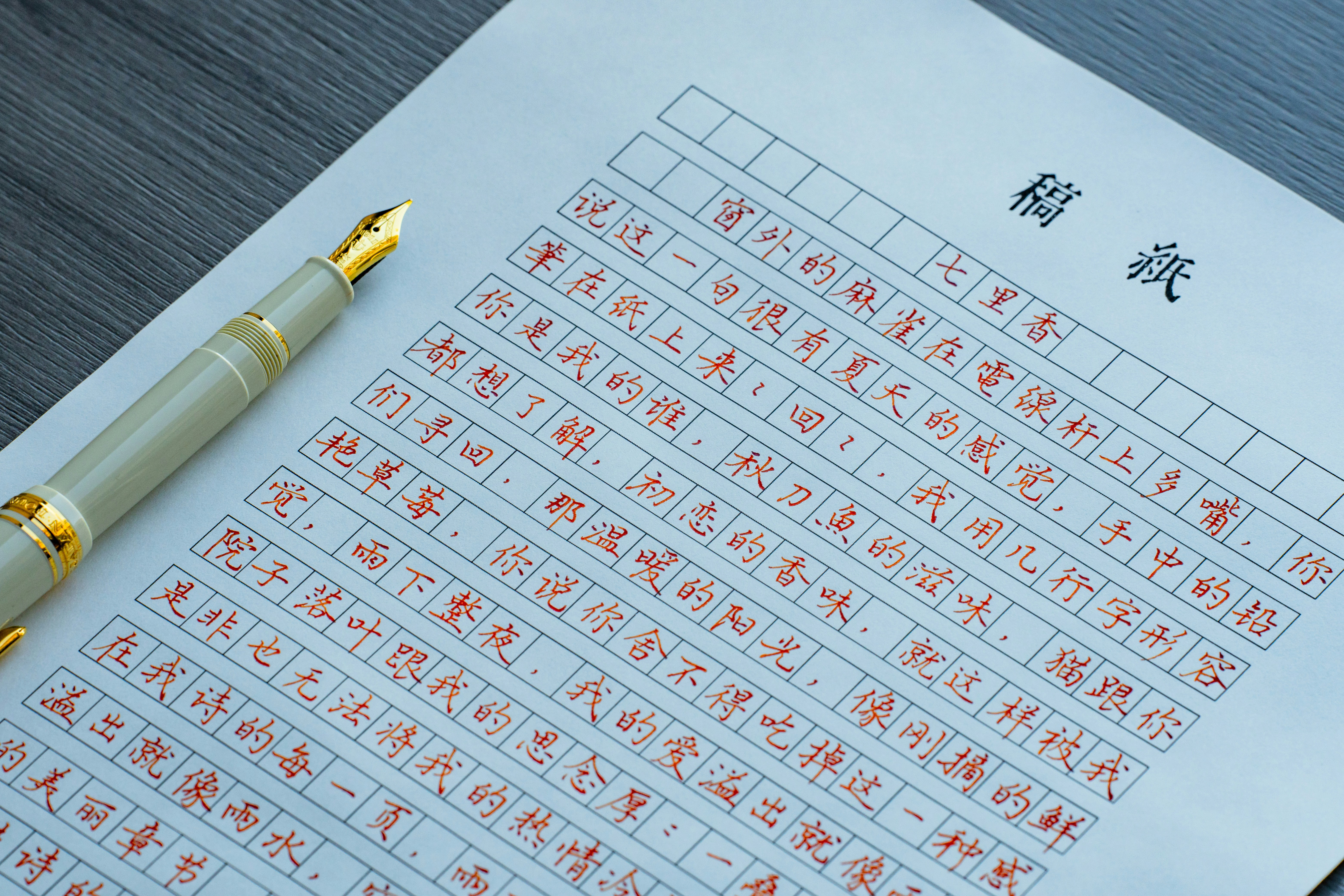Golden Pen Over orderly script: a close-up of a fountain pen poised above a Chinese manuscript