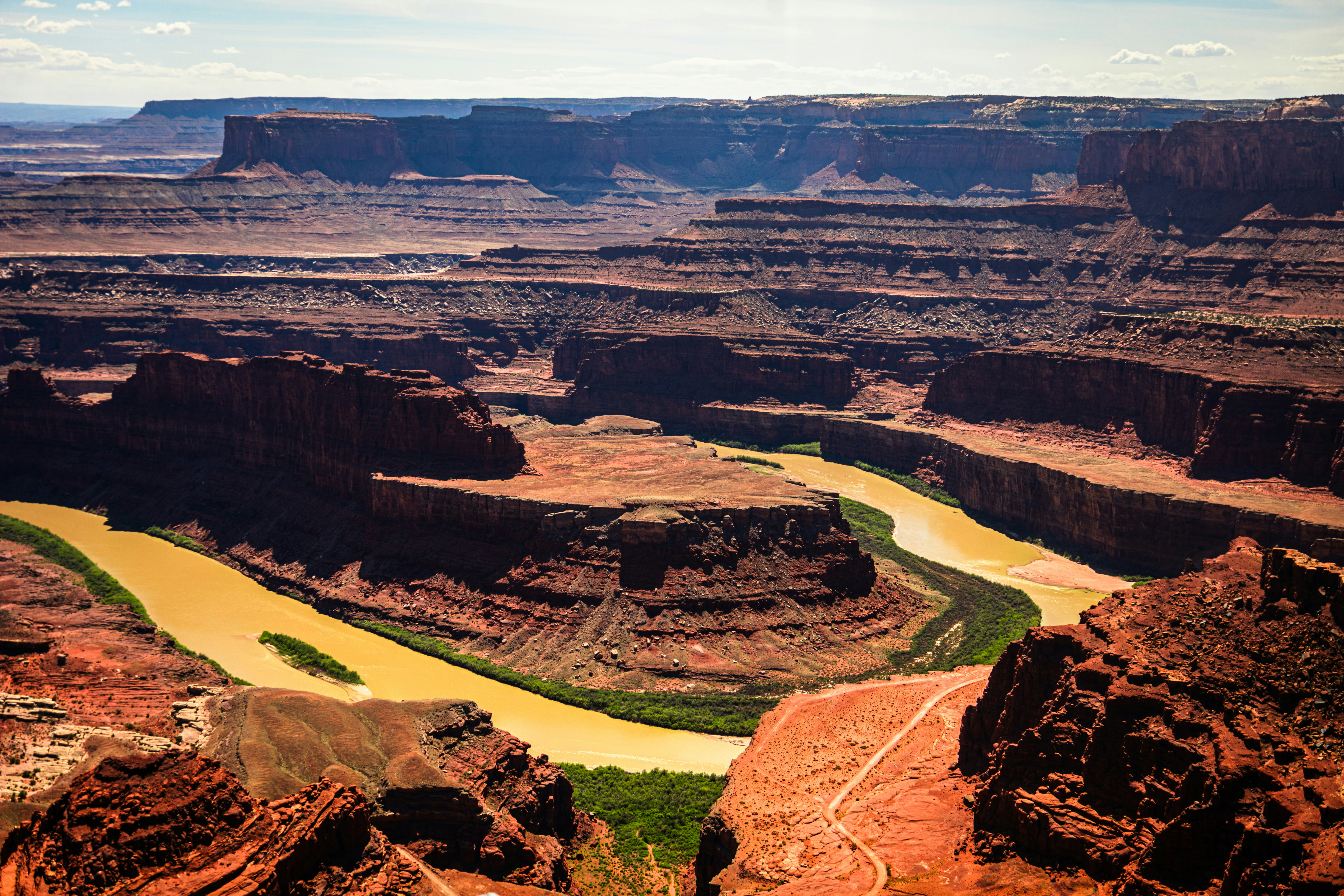 Meandering Green Ribbon Through Red Canyon Walls
