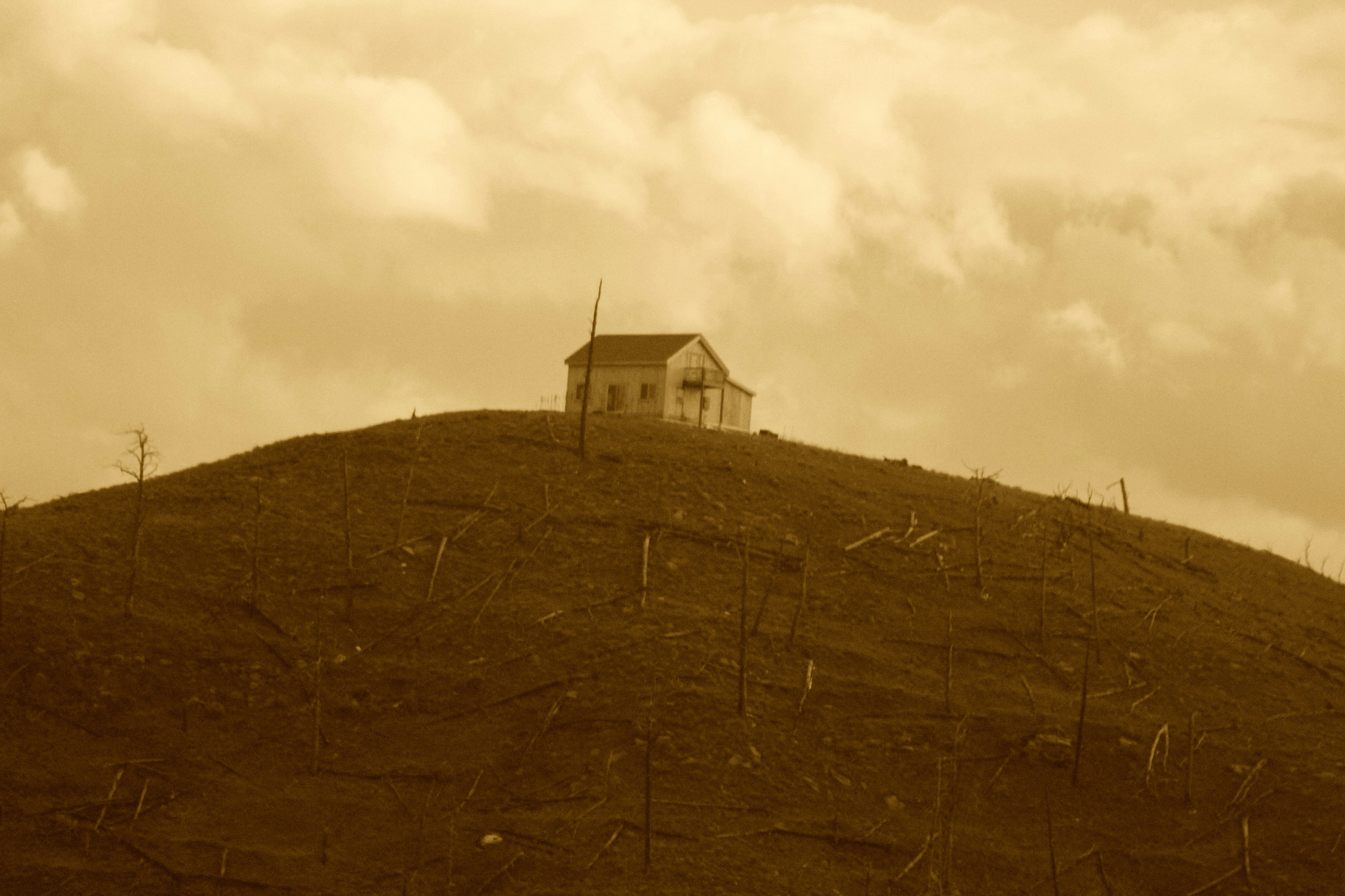 Hilltop Shack Beneath a Weathered Sky