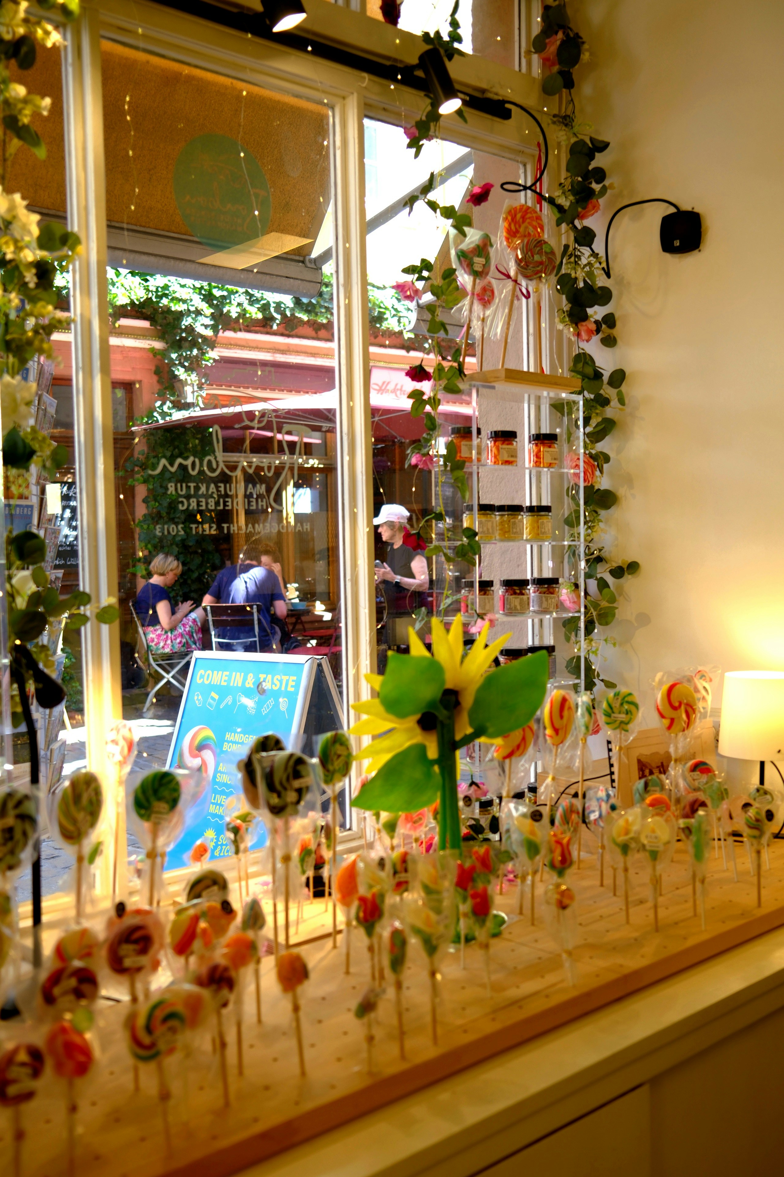 Candy Display and Sunlit Cafè Through Glass