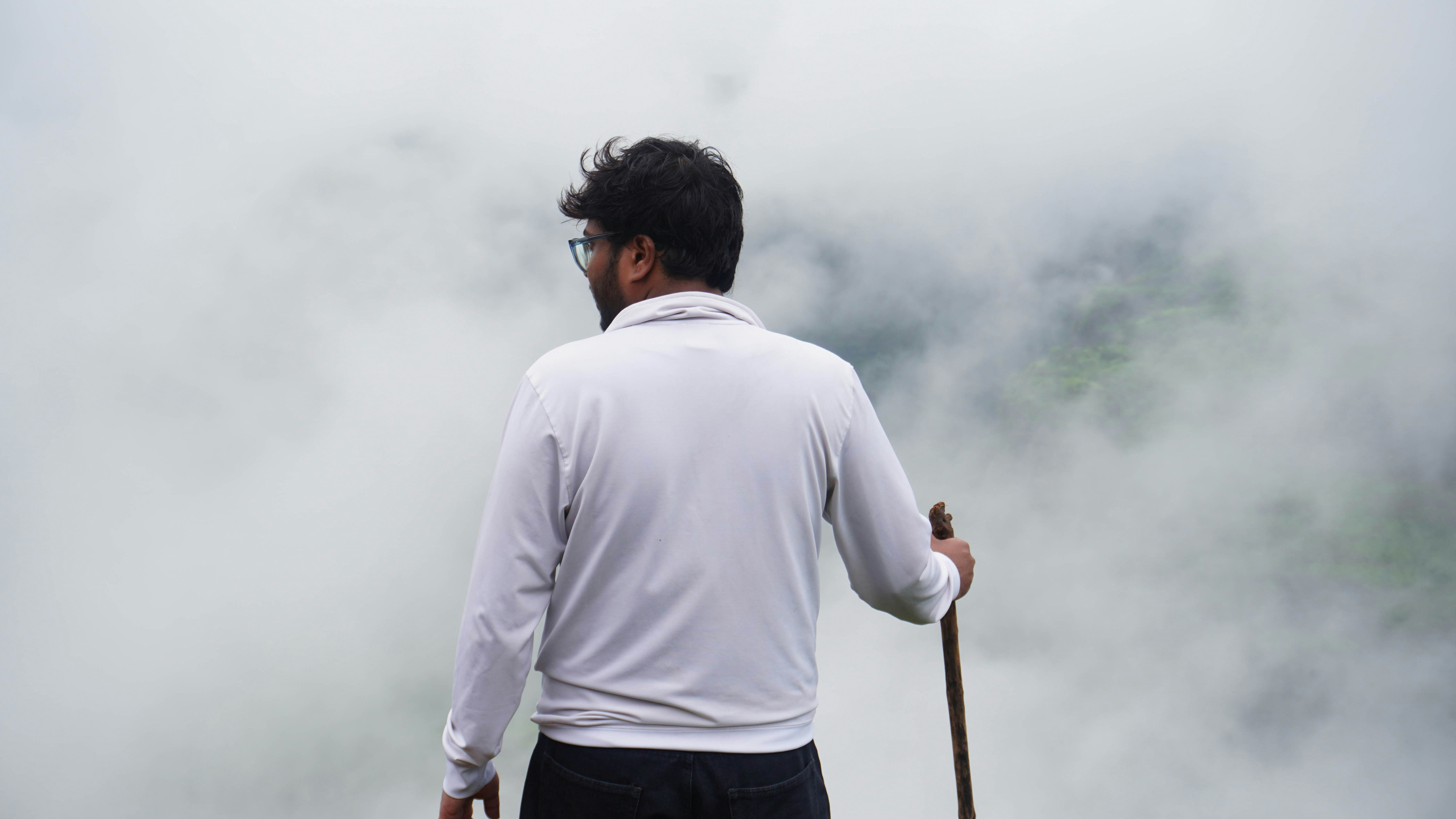 Between Clouds and Cliffs: A Guide's Silhouette in Mist