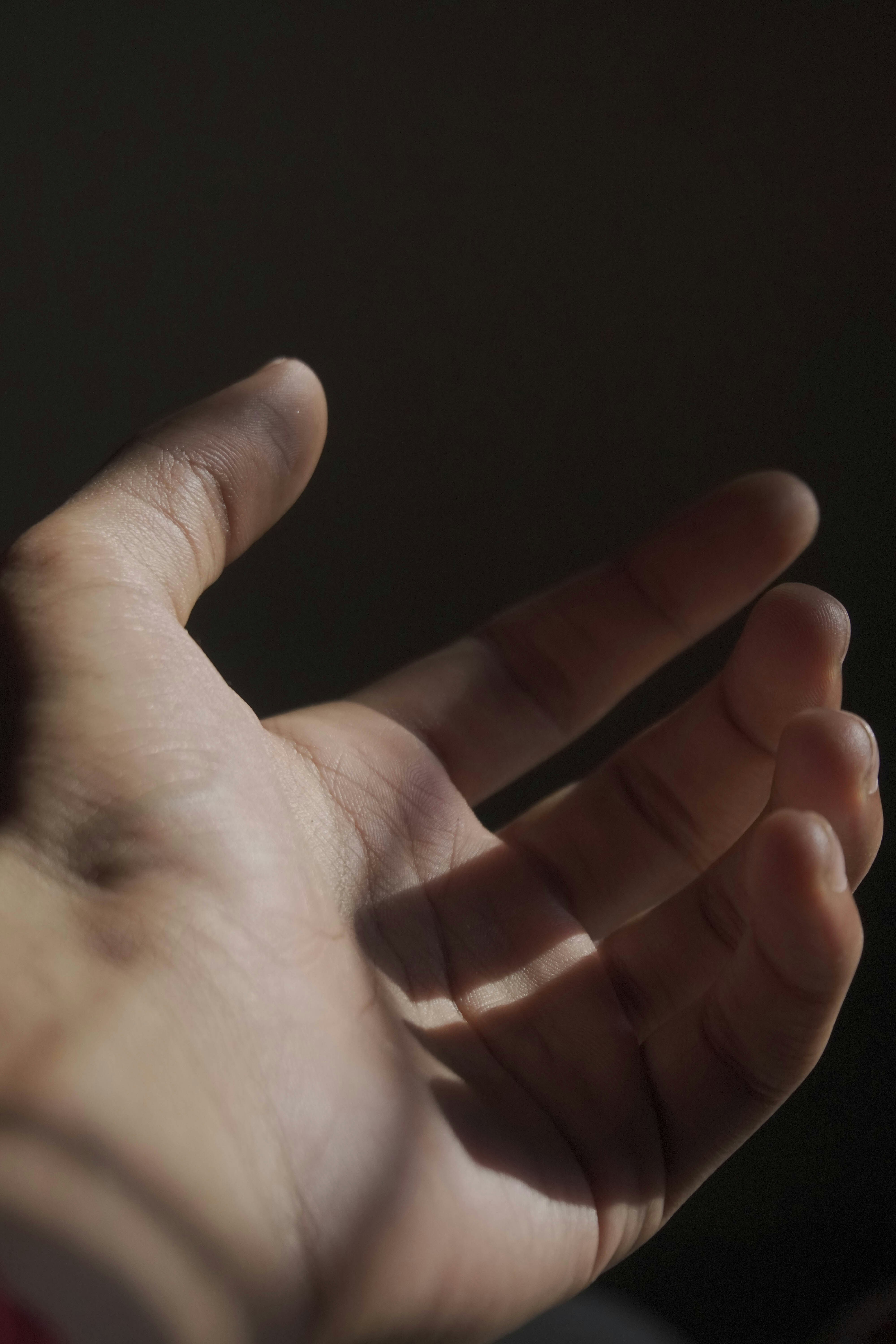 Open Palm in Soft Light: A Quiet Hand Gesture Against a Dark Backdrop