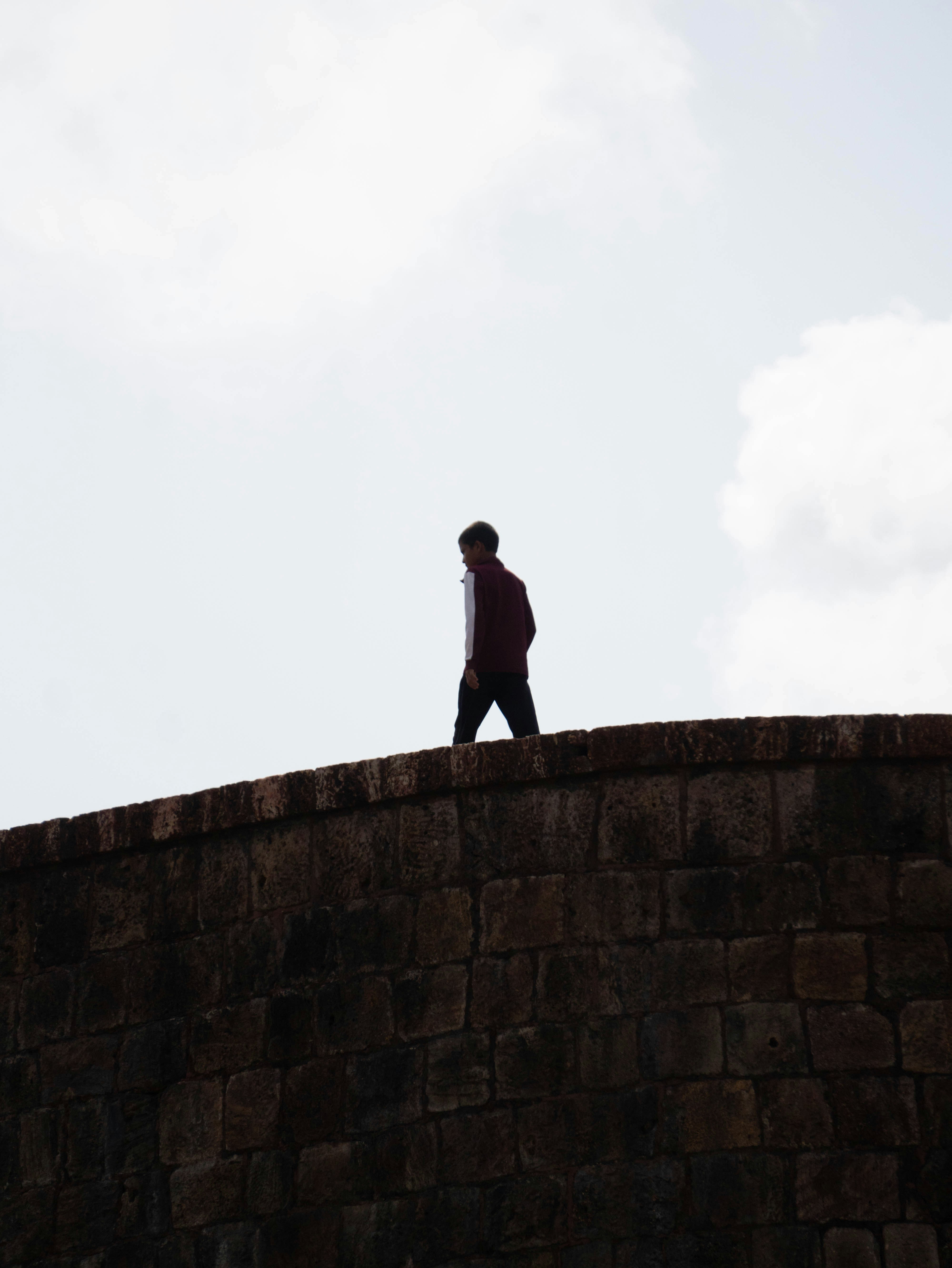A Quiet Crossing: Figure Looms Over the Ancient Wall at Dusk
