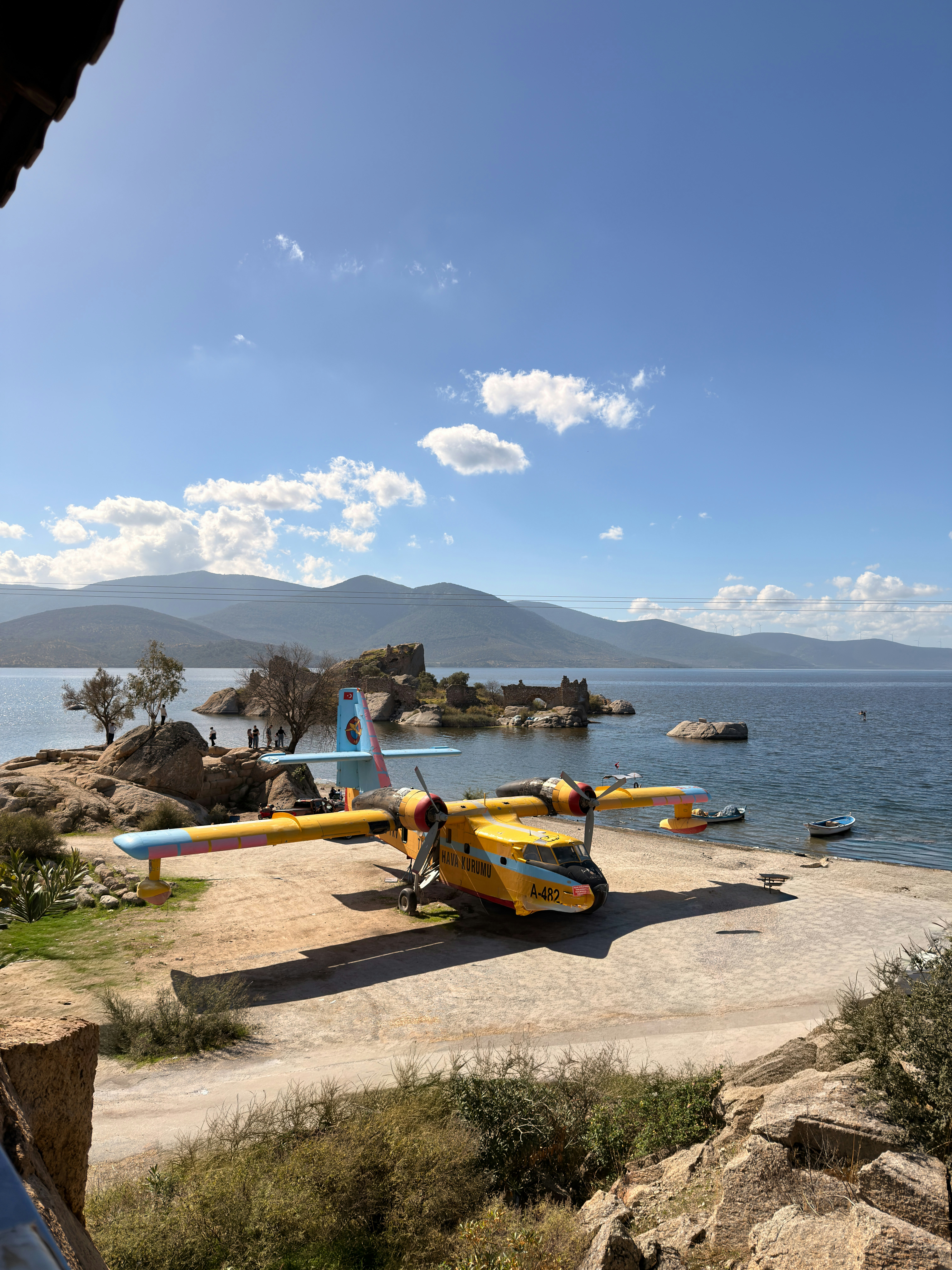 Colorful seaplane on a sunlit lakeside, with distant mountains