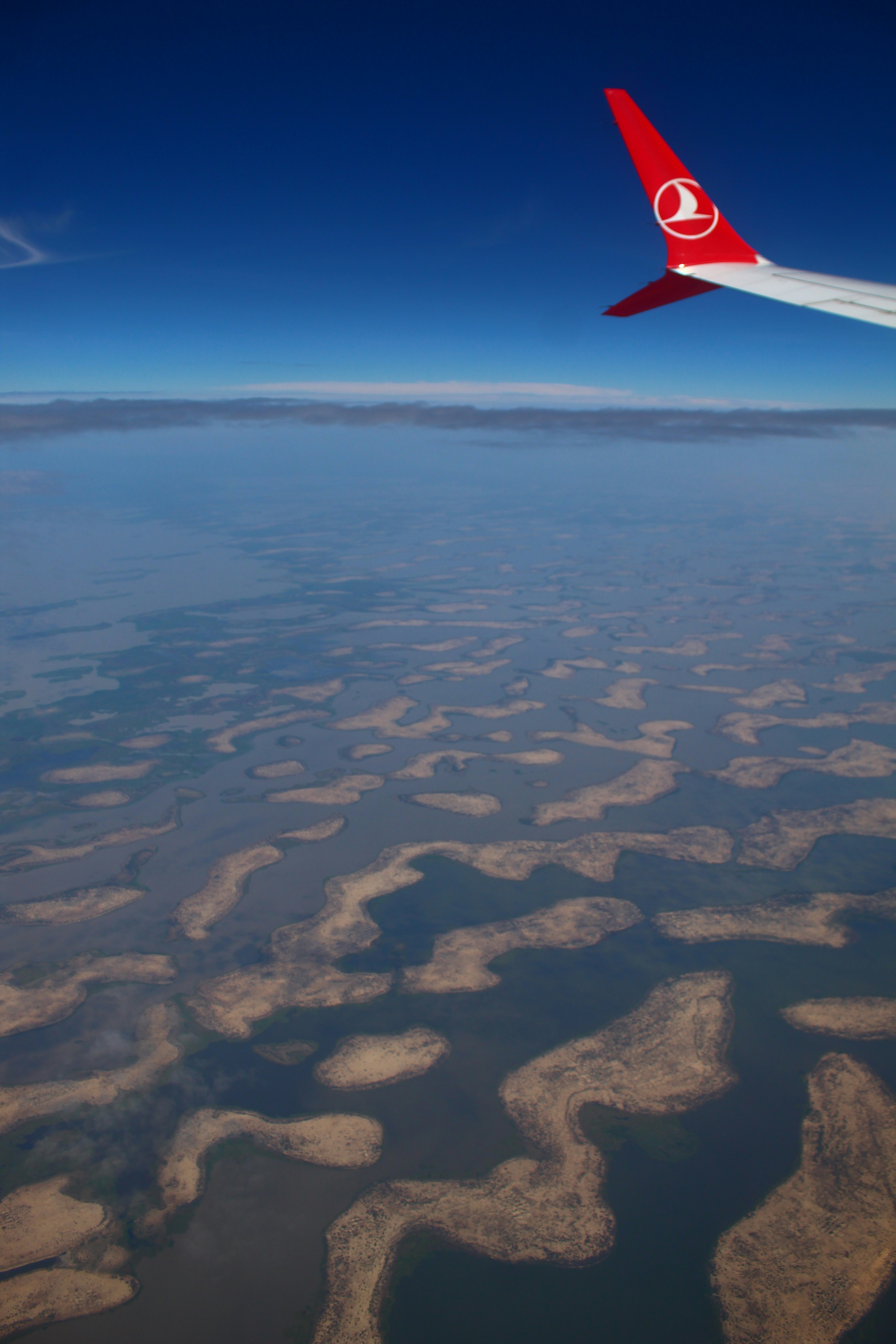 Red Wing, Blue Sky: Aerial View Over Desert intrigues from the Window
