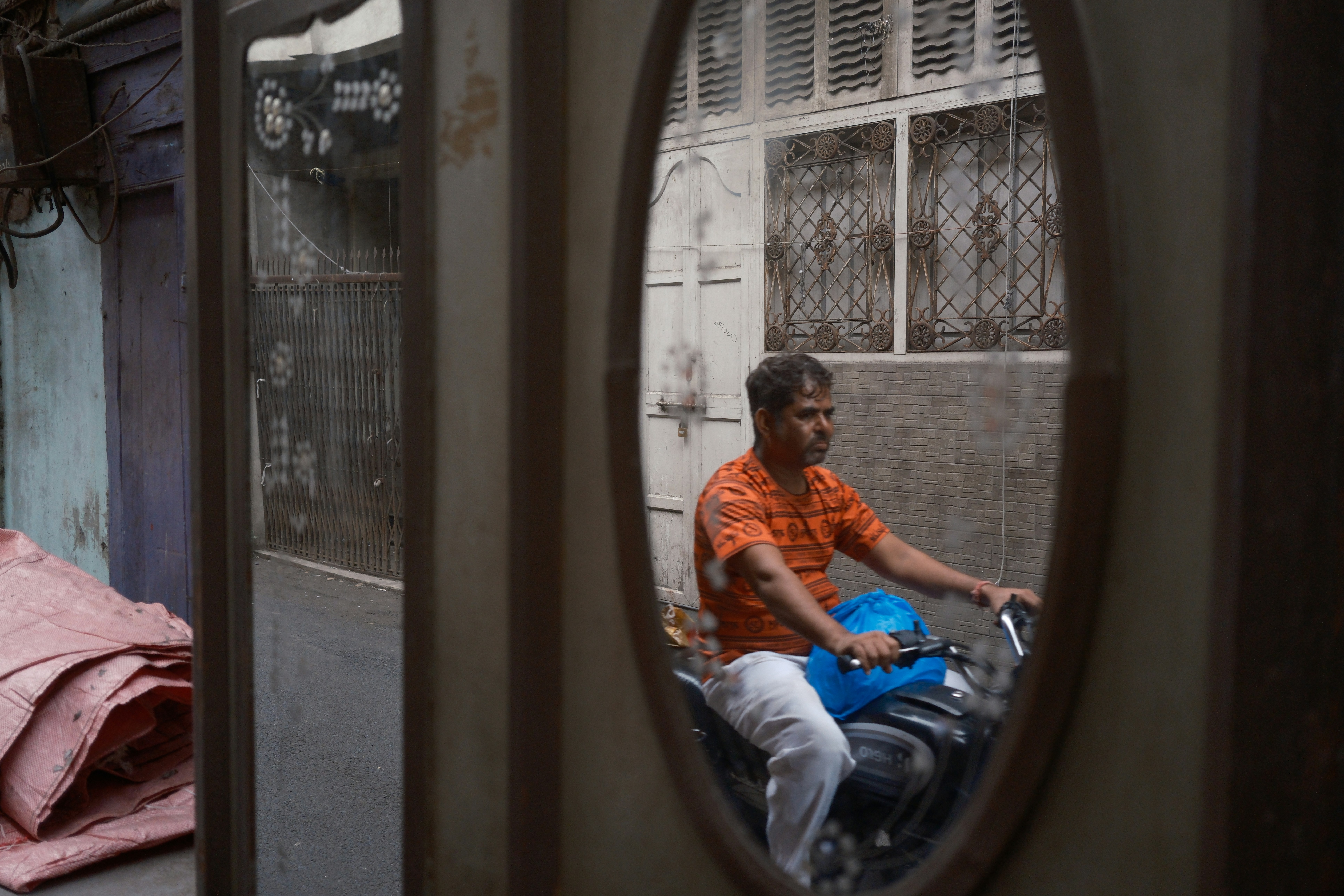Through the Oval Frame: A Rider Pauses in a Narrow Alley
