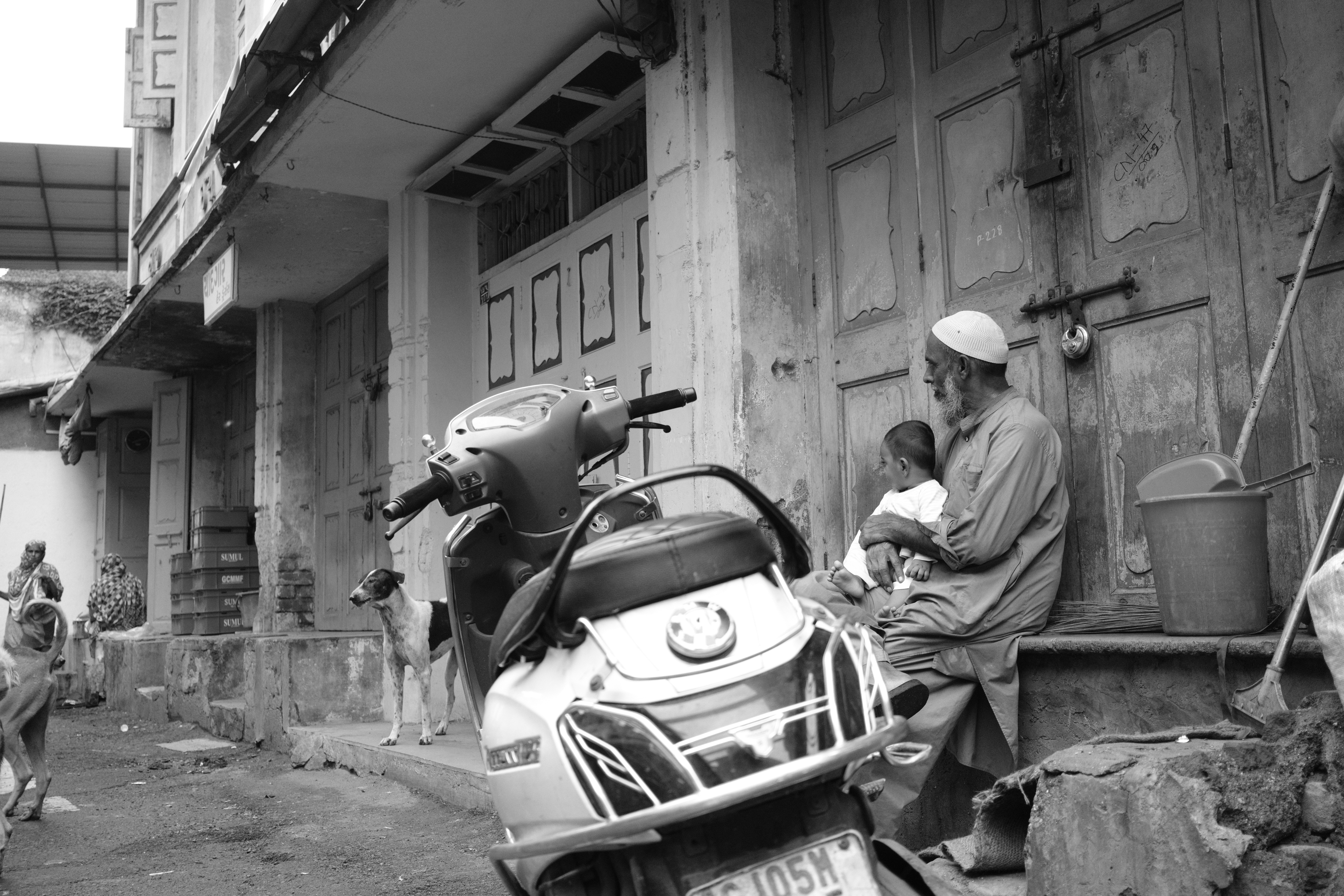 Quiet Resolve on a City Gate: A Father and Child by the Scooter
