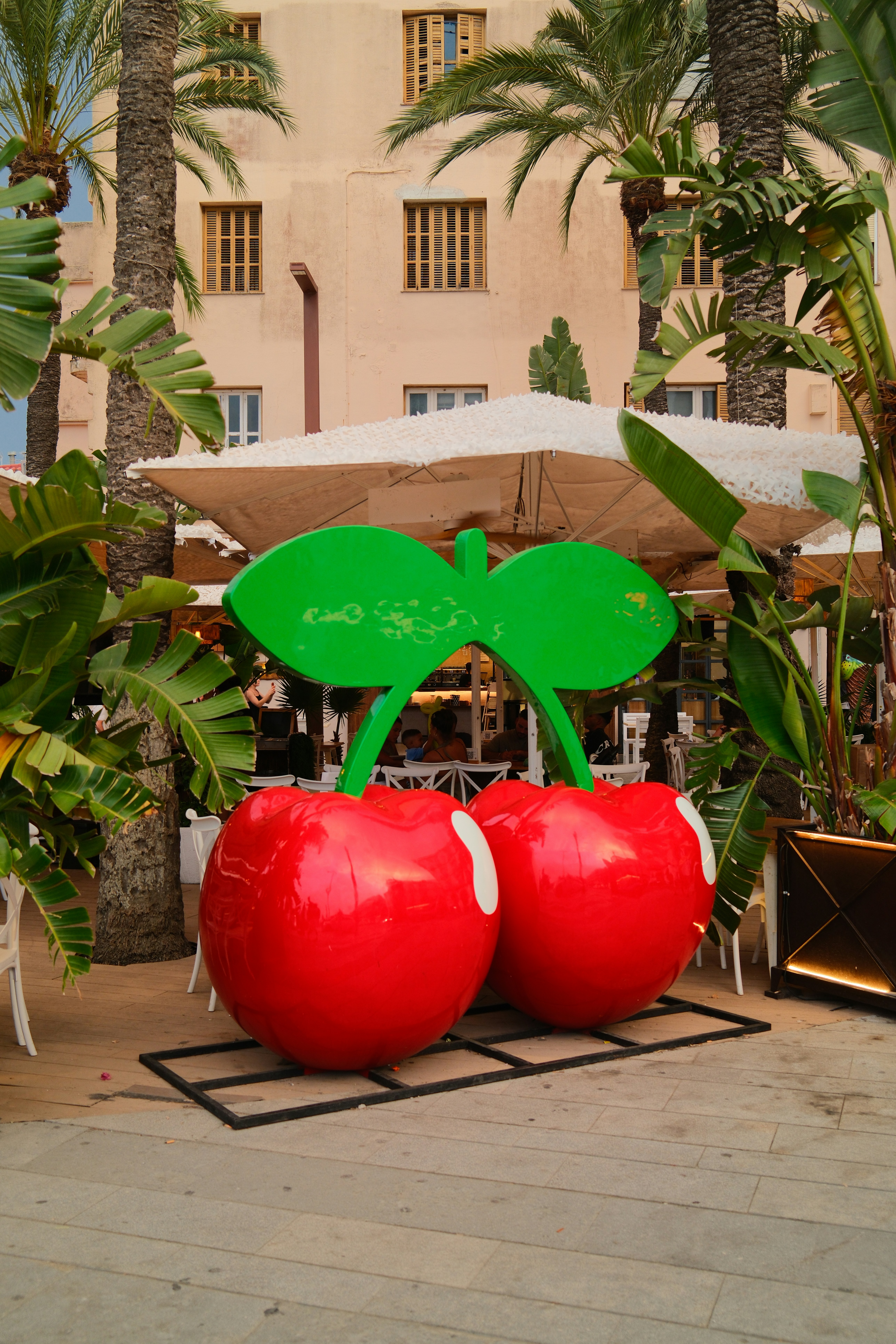 Juxtaposition of Nature and Leisure: A Striking Cherries Sculpture at Palm Oasis