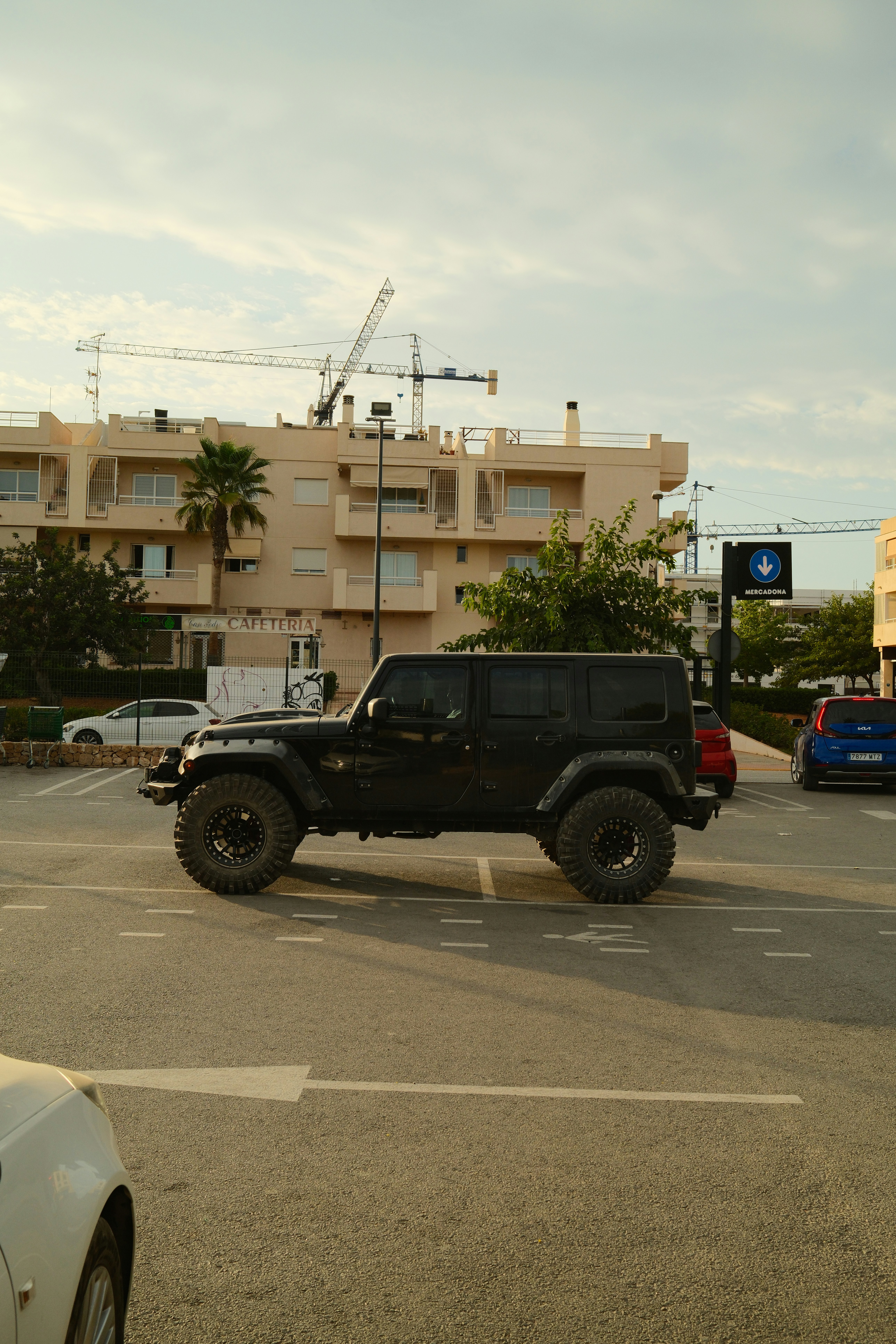Urban Off-Road Crown: A Stocky Jeep Dominates a Sunset Parking Lot