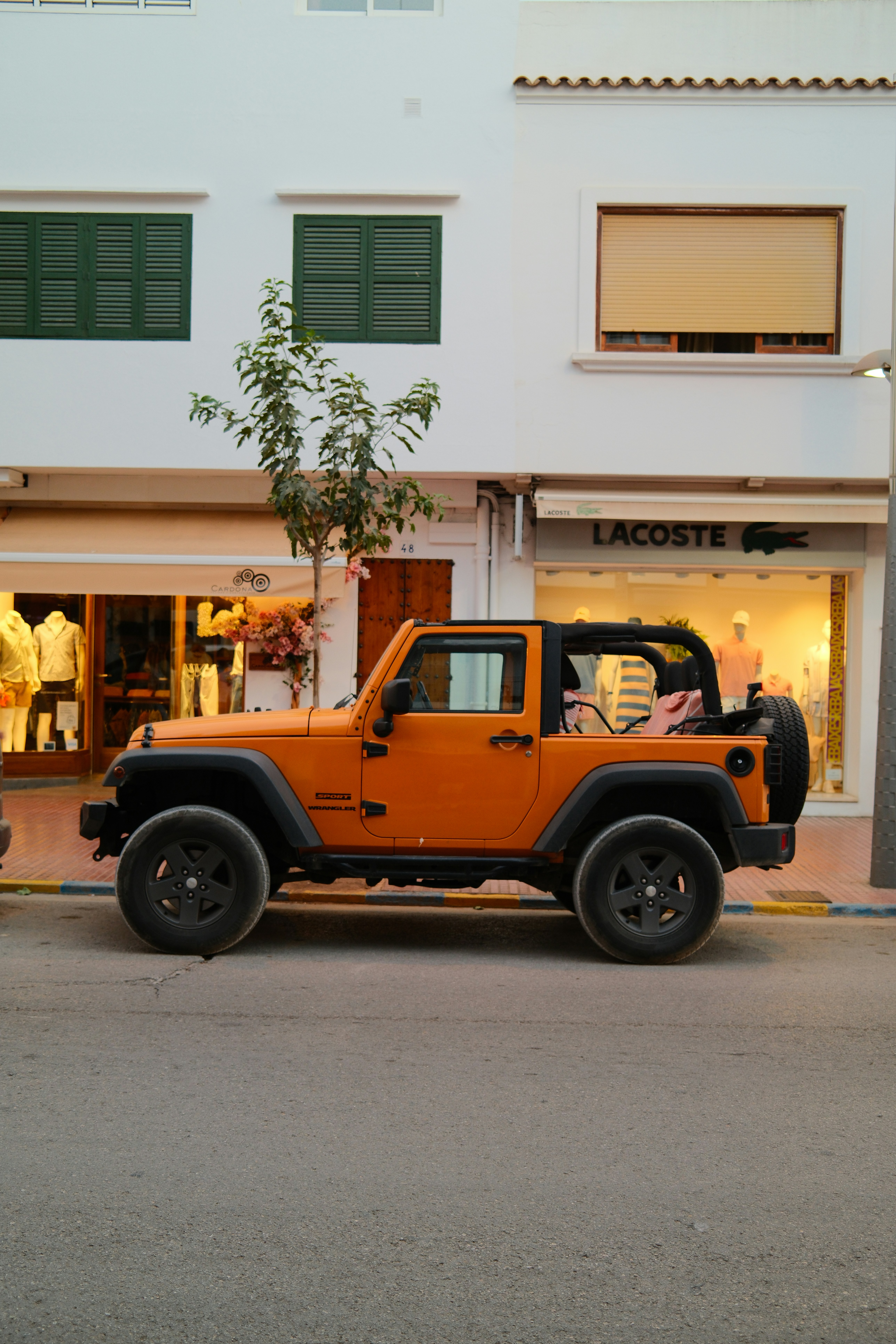 Orange Jeep on a Sunlit Streetfront