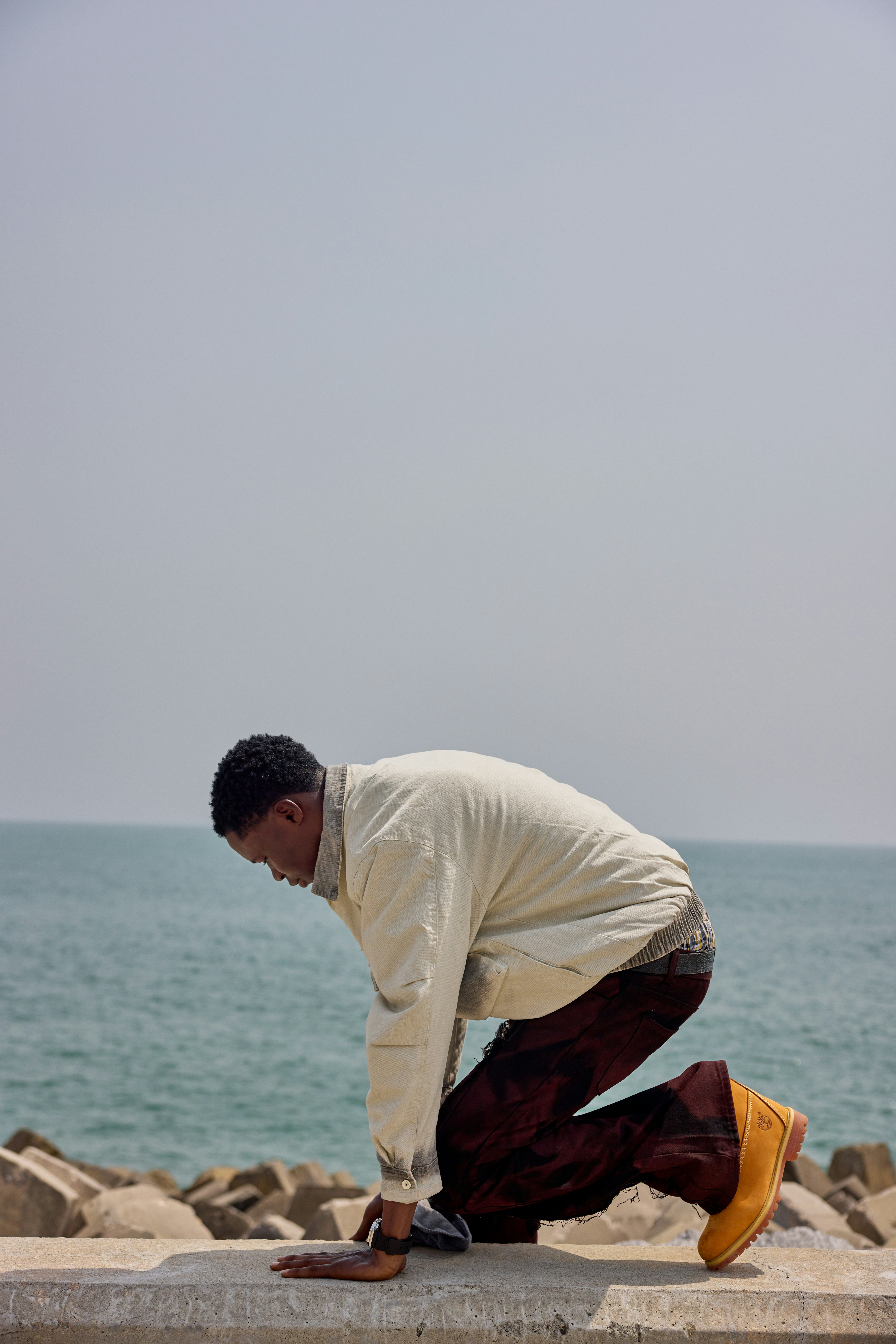 Leaning toward the Edge: A Seated Pose Against the Sea Horizon