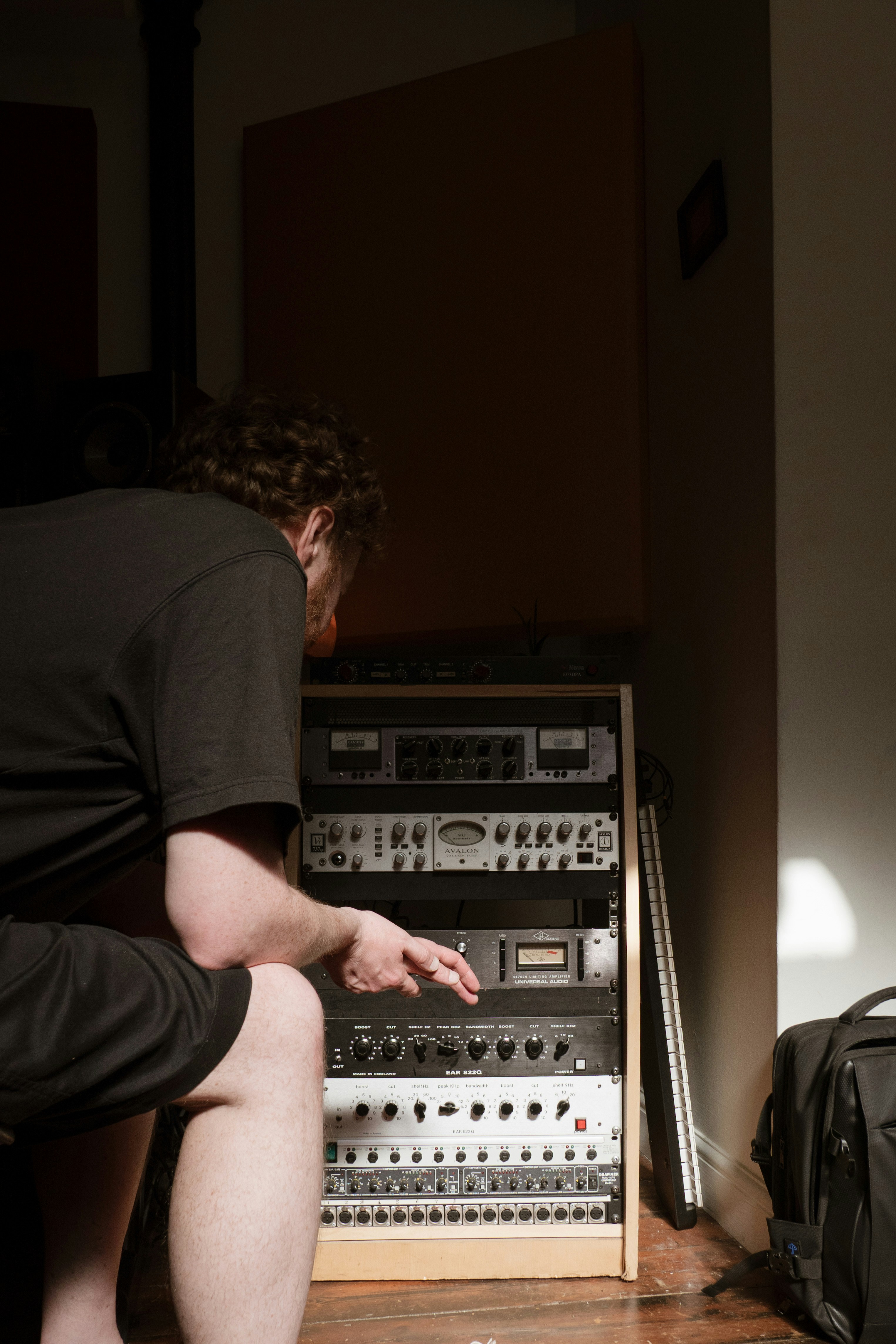 Sound Engineer at Work: Tuning the Rack in a Dim Studio