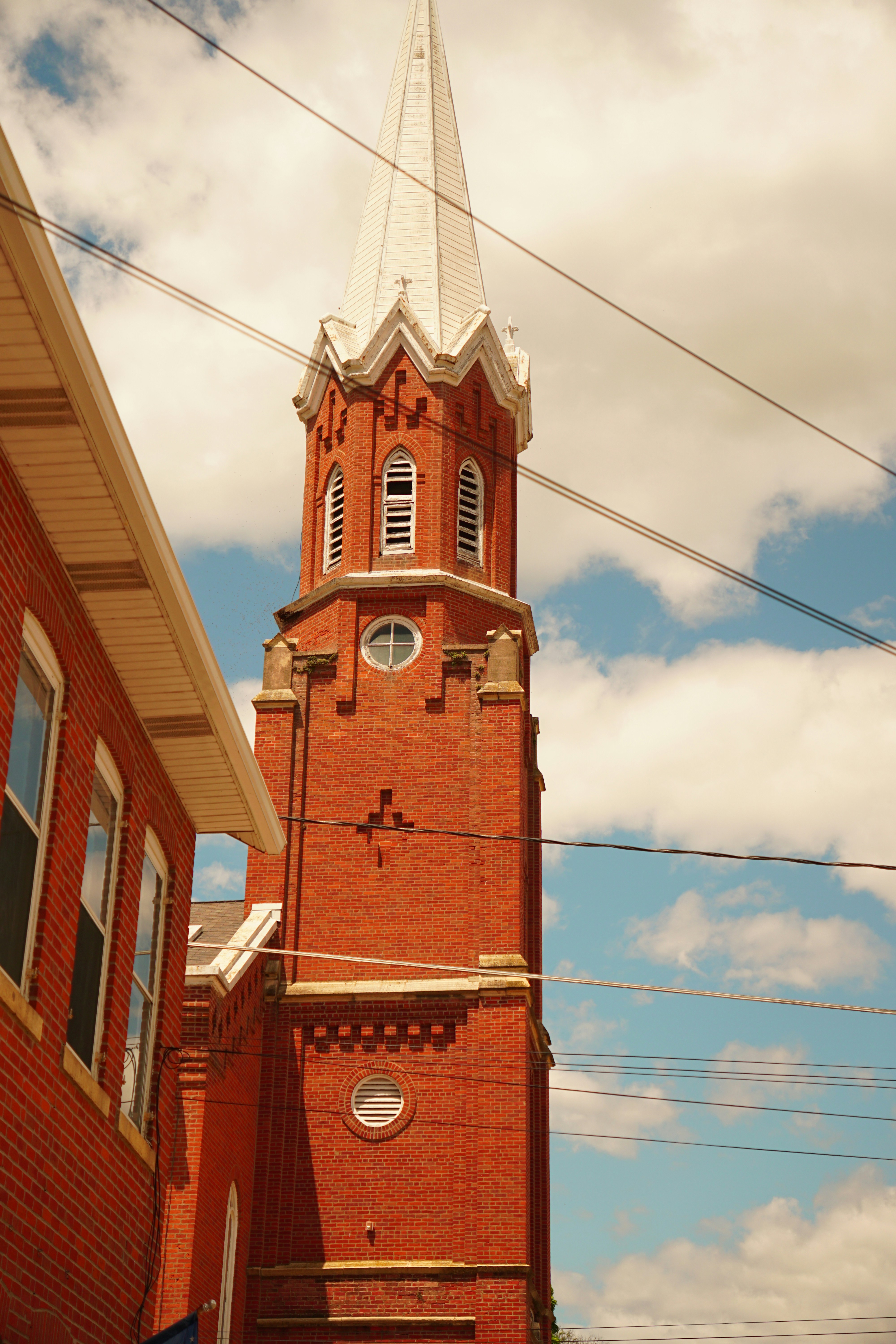 Brick Clocktower Rising Through Wires on a Sunny Day