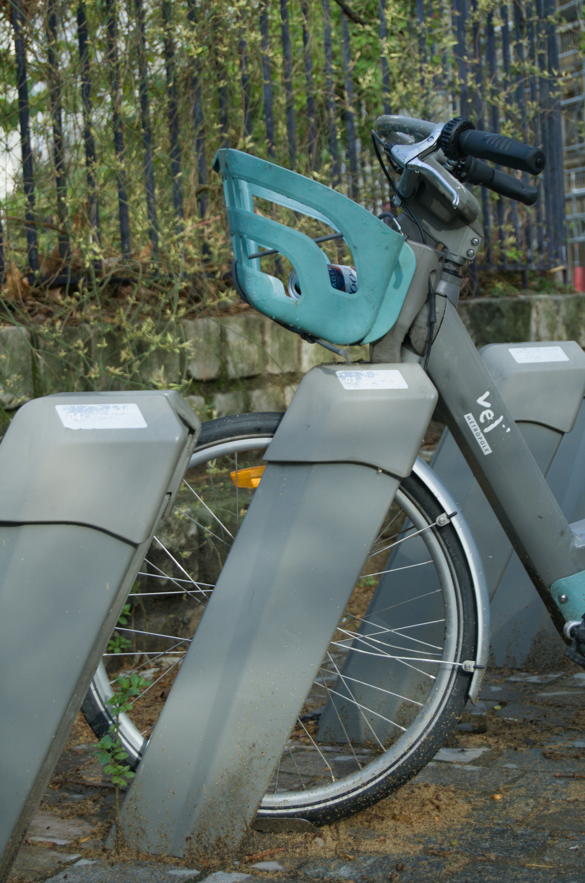 Docked at the curb: a teal child seat perched on a rideshare bike